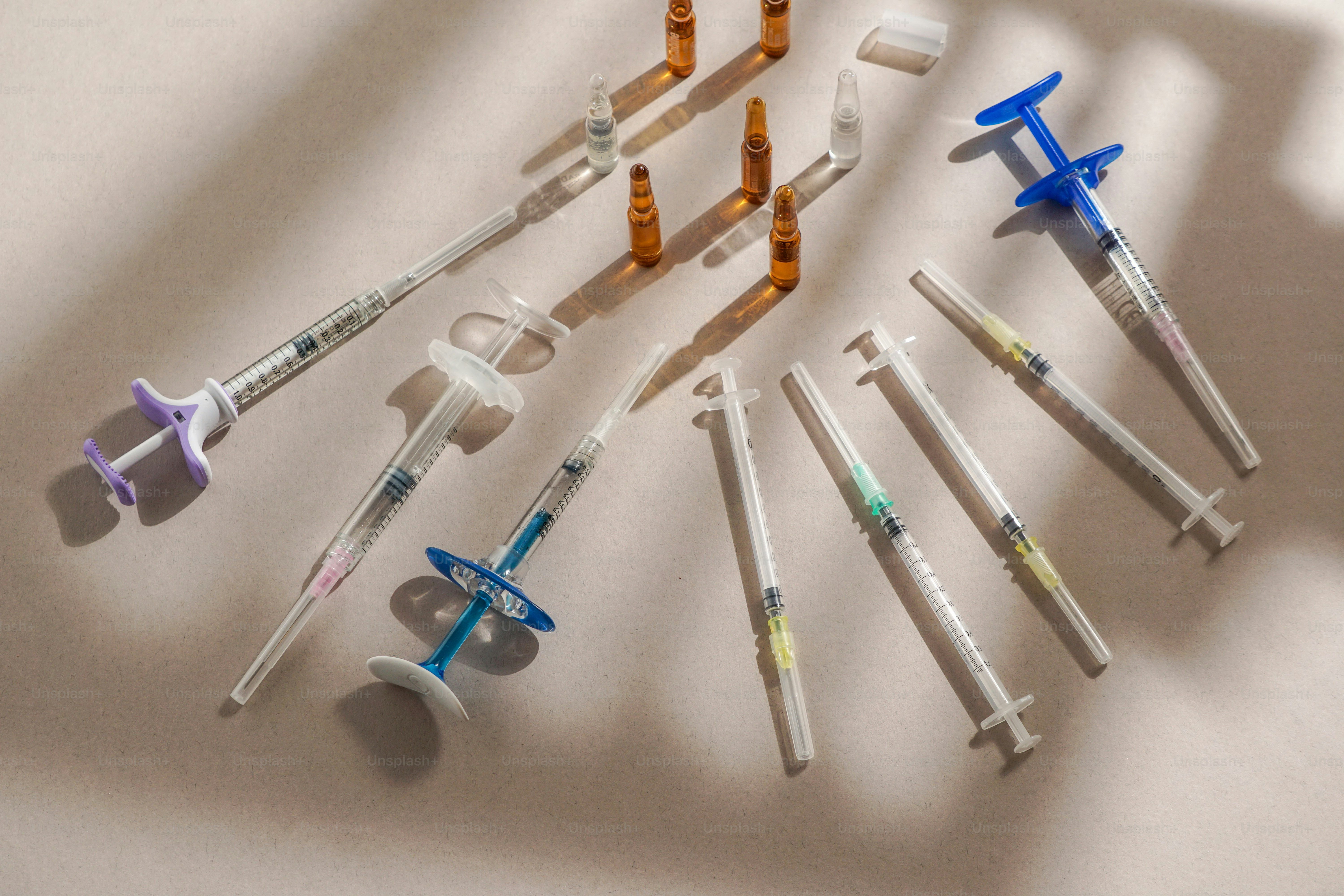 Medical syringes and vials are arranged on a surface. photo – Health ...