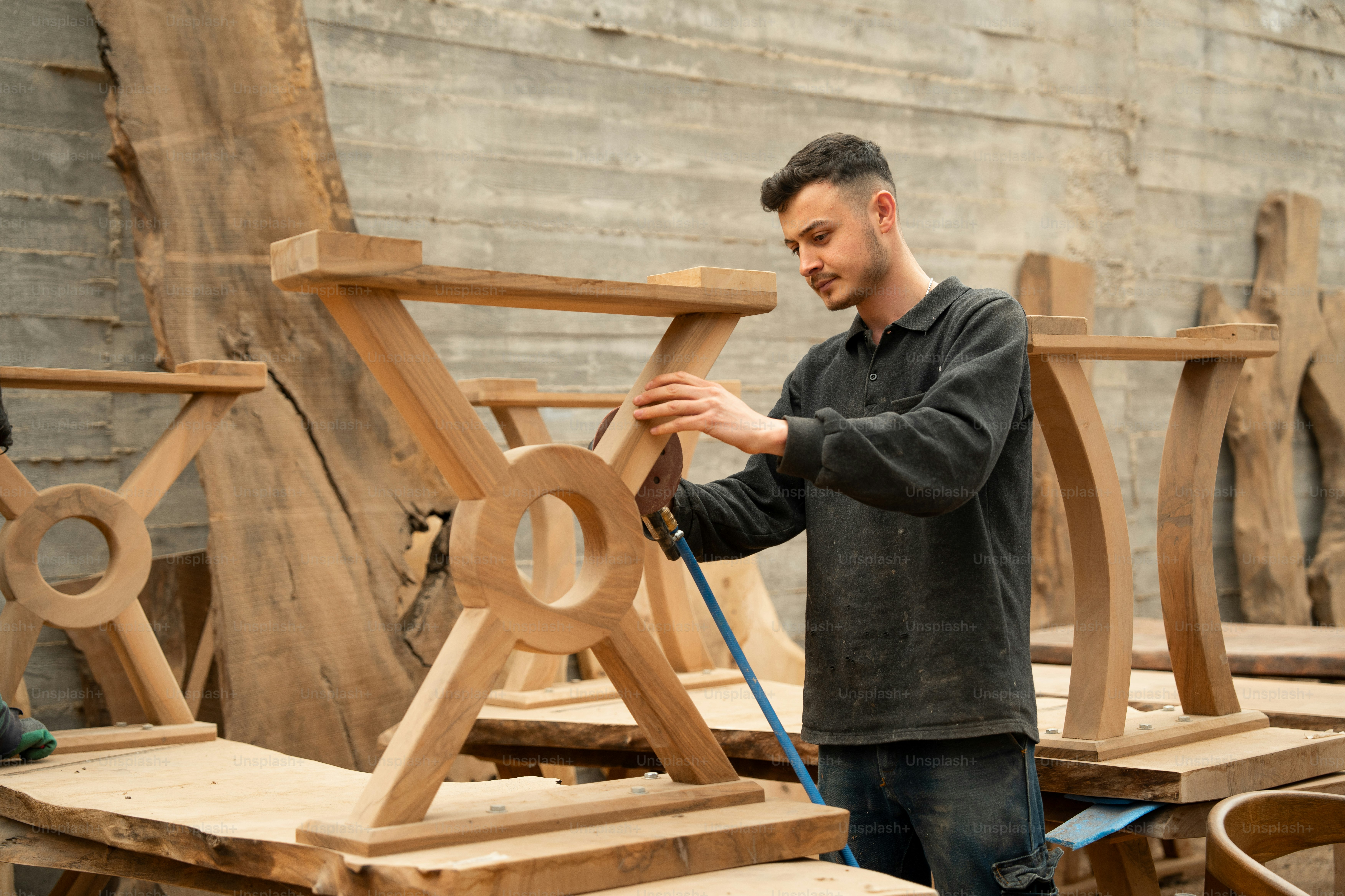 A woodworker assembles a wooden table frame. photo – Luxury Image on ...