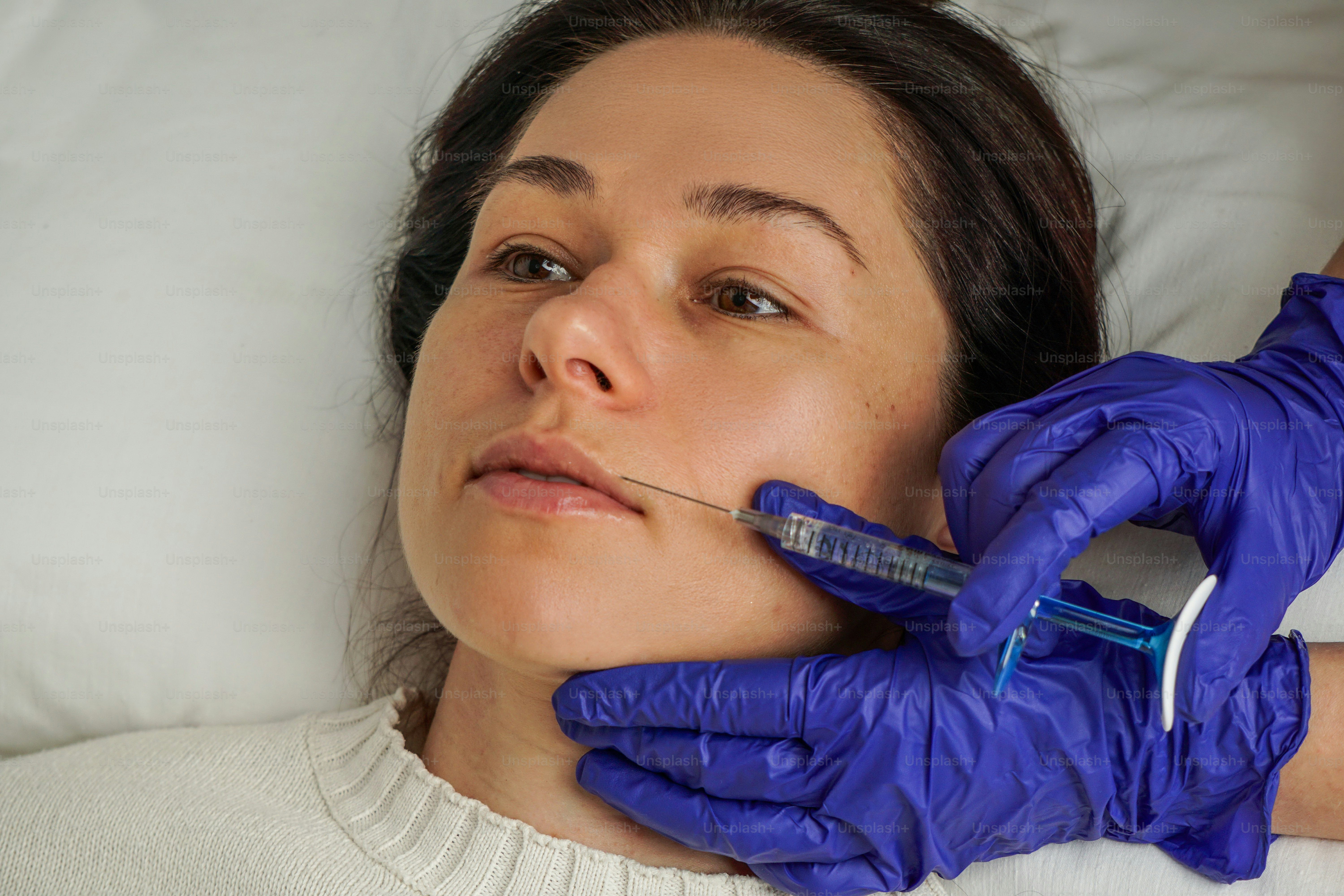Woman receives lip filler injections for aesthetic treatment. photo ...