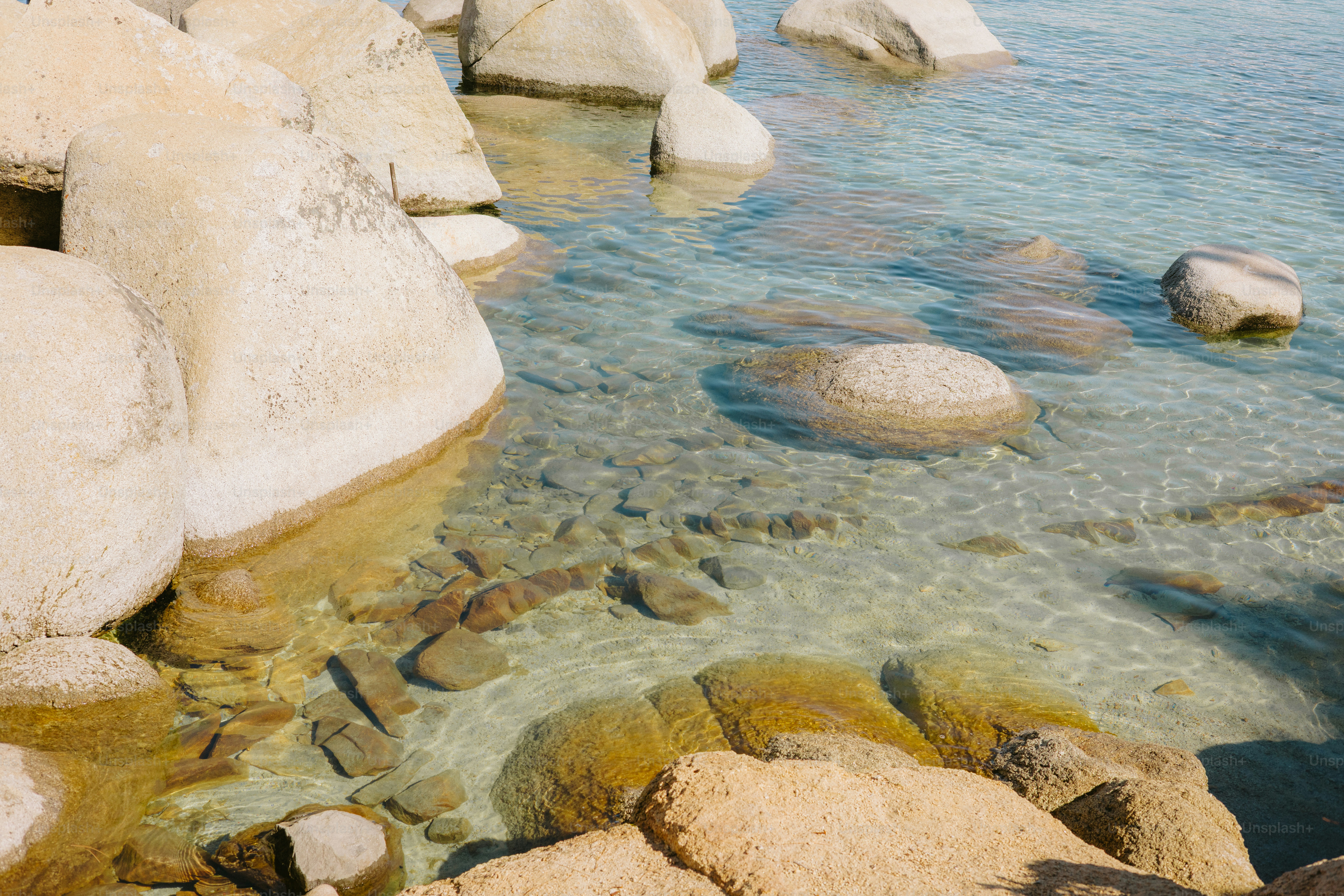 Rocks and clear water are shown in the image. photo – Texture Image on ...