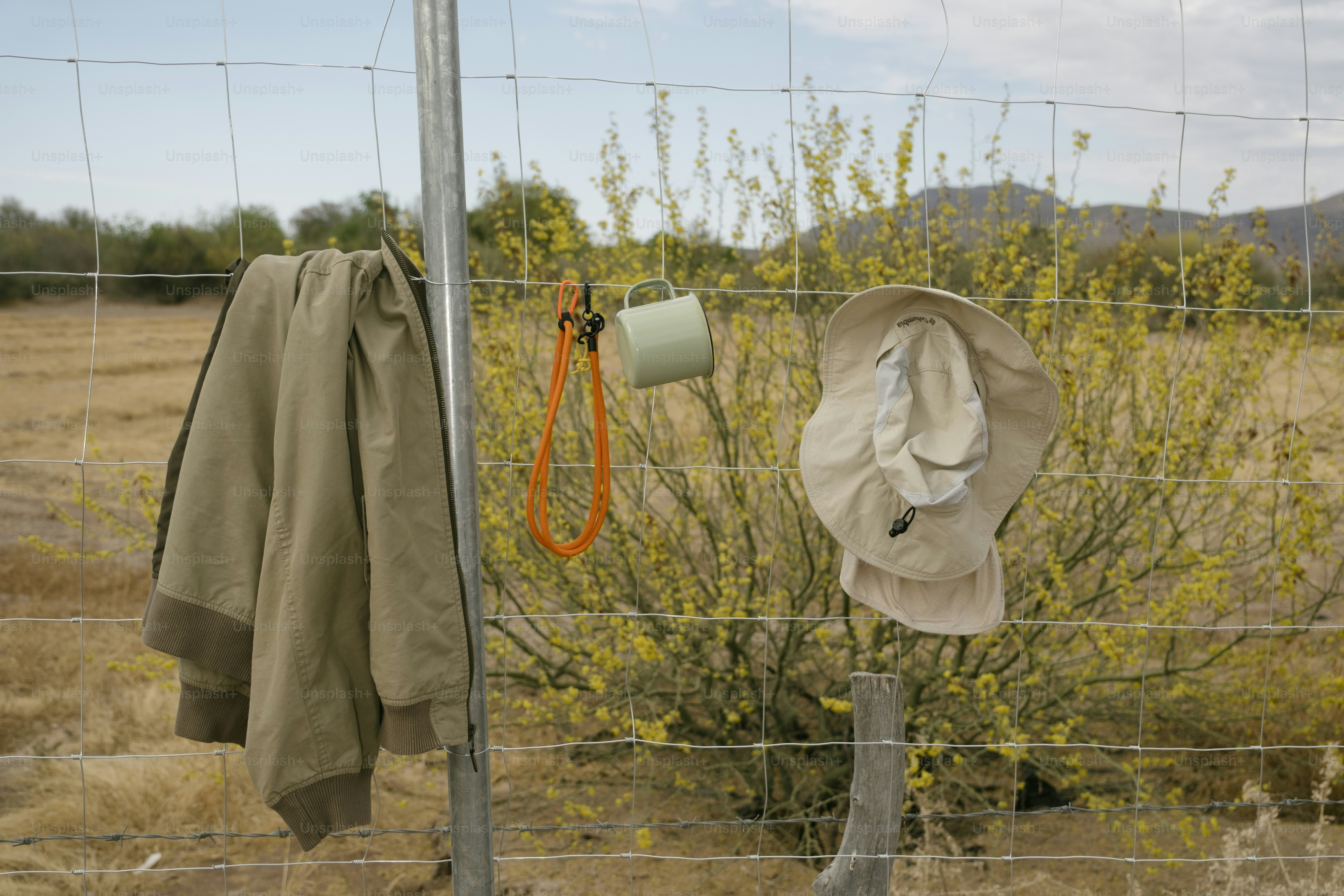 Clothing hangs on a wire fence in the field. photo – Travel Image on ...