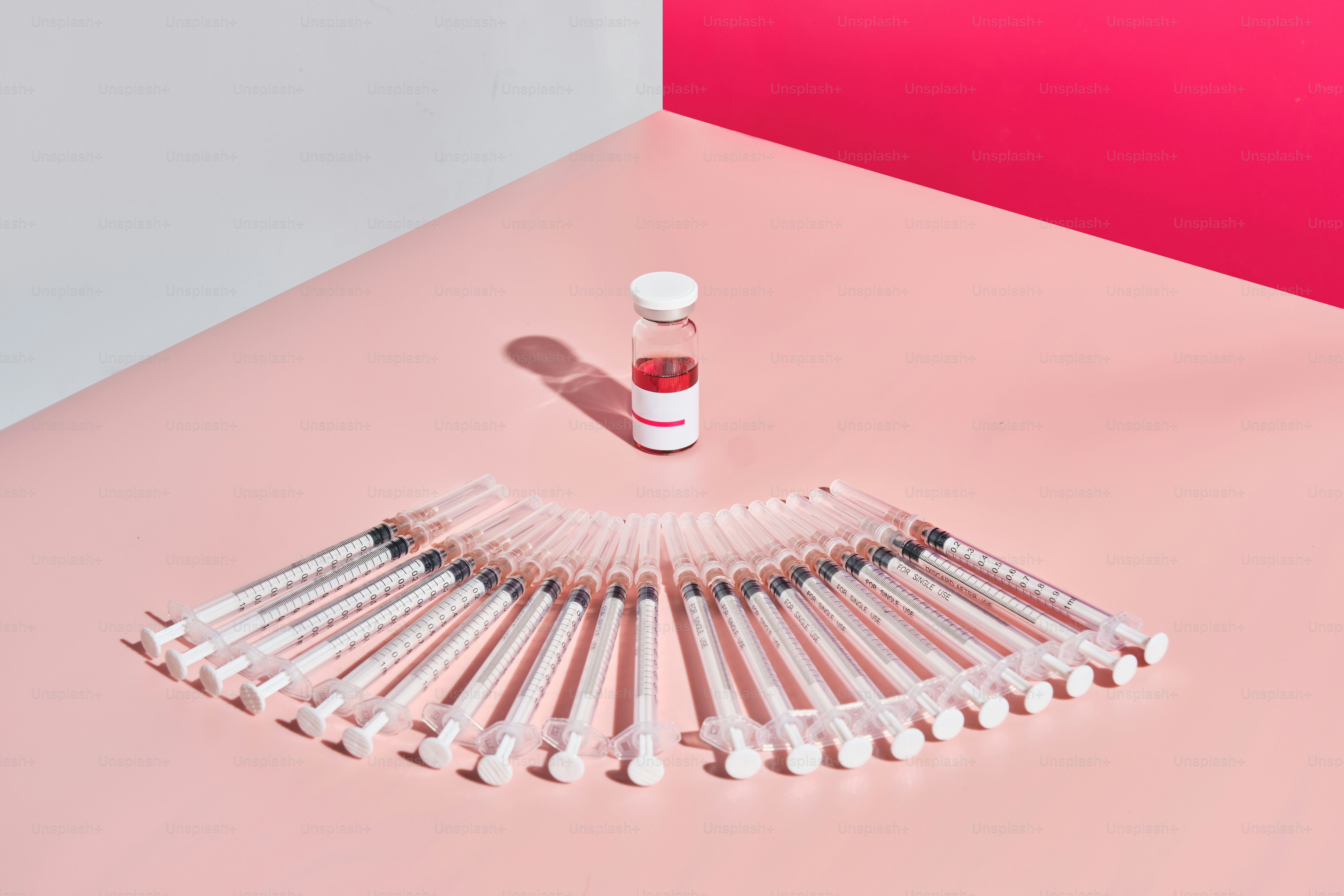 Syringes and vials arranged on a pink surface. photo – Health Image on ...