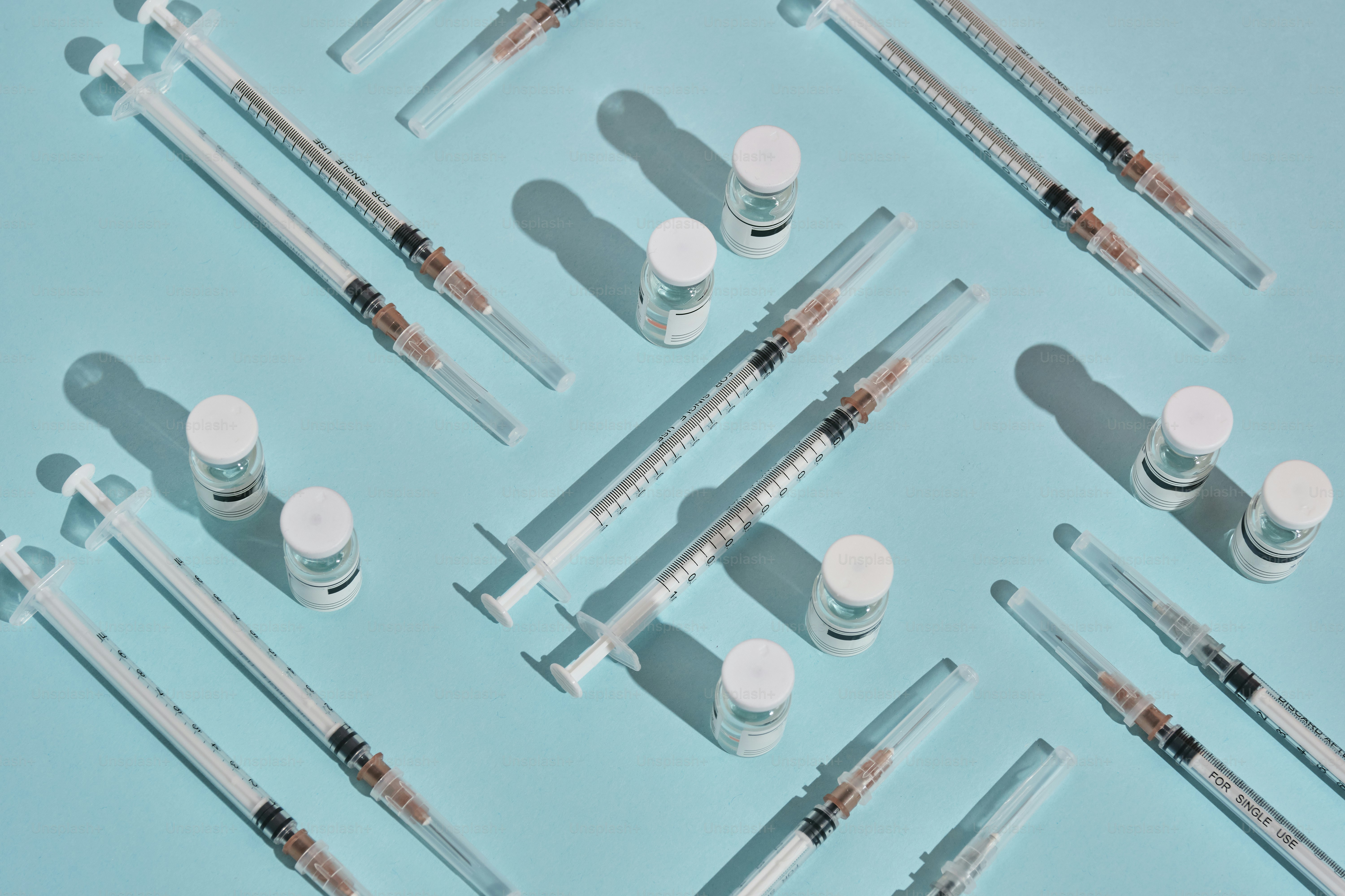 Syringes and vials arranged on a blue background. photo – Health Image ...