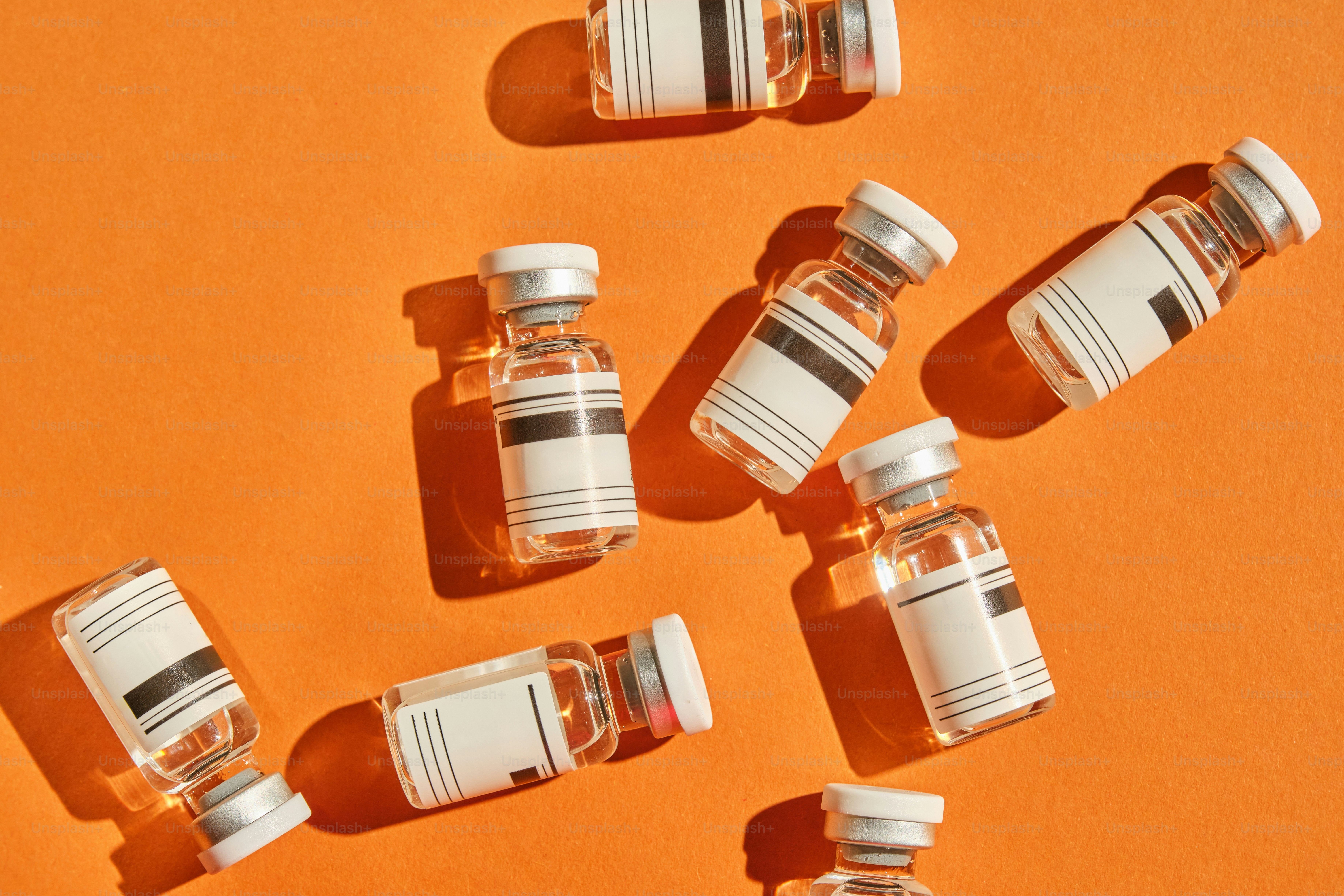Vials of medicine are scattered on an orange surface. photo – Health ...