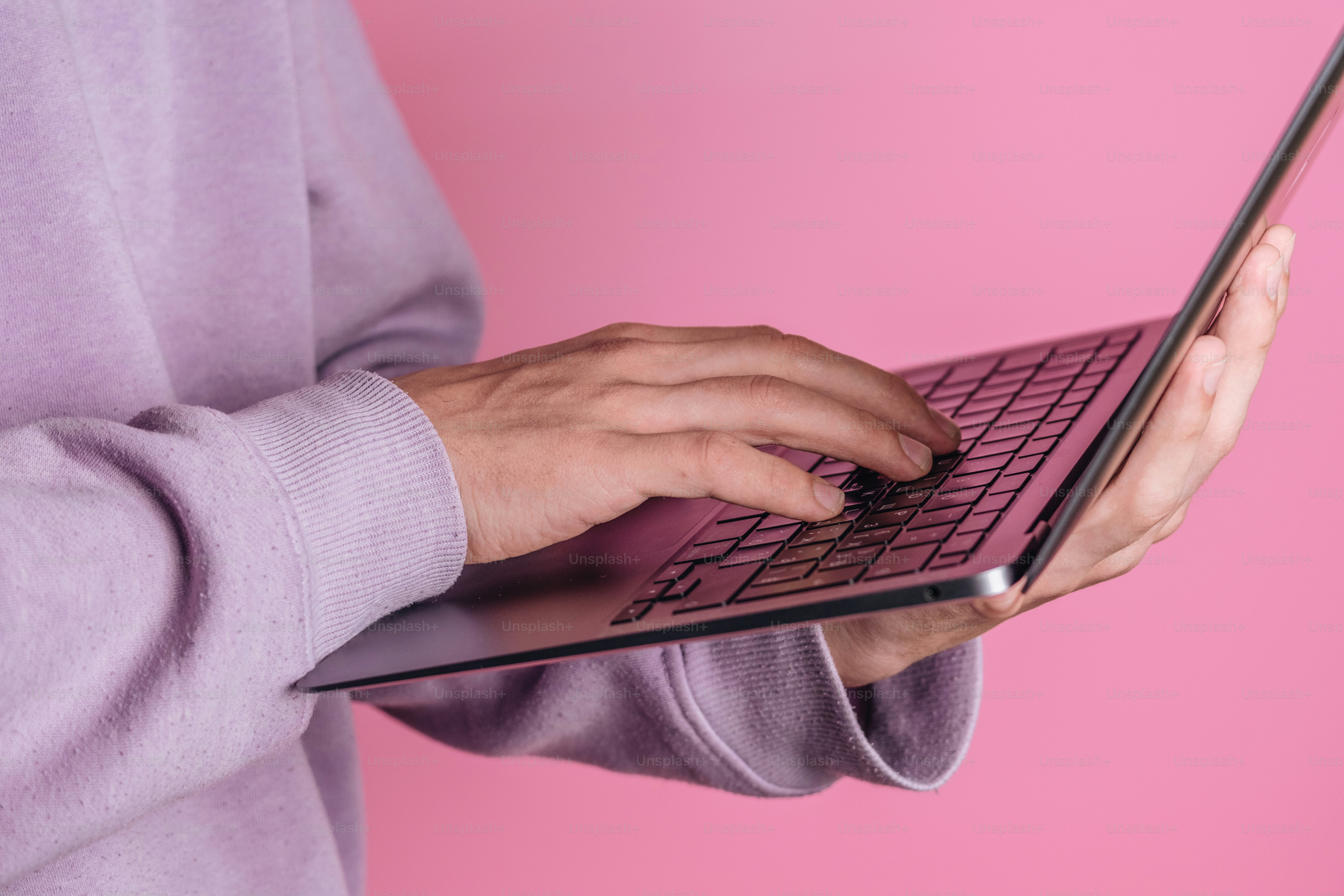Persona con camisa morada escribe en la computadora portátil. foto ...