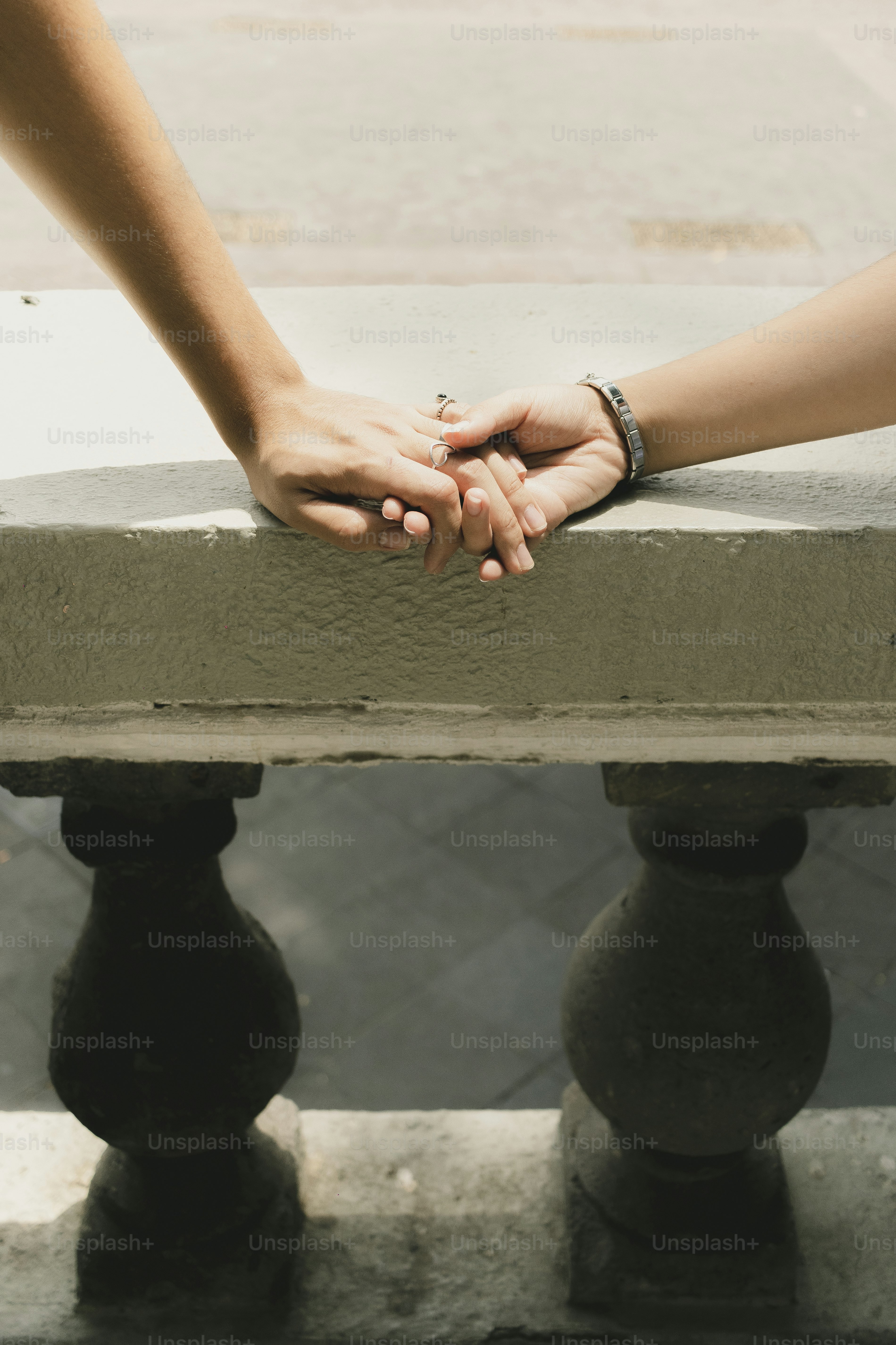 People hold hands on a concrete ledge. photo – Hands Image on Unsplash