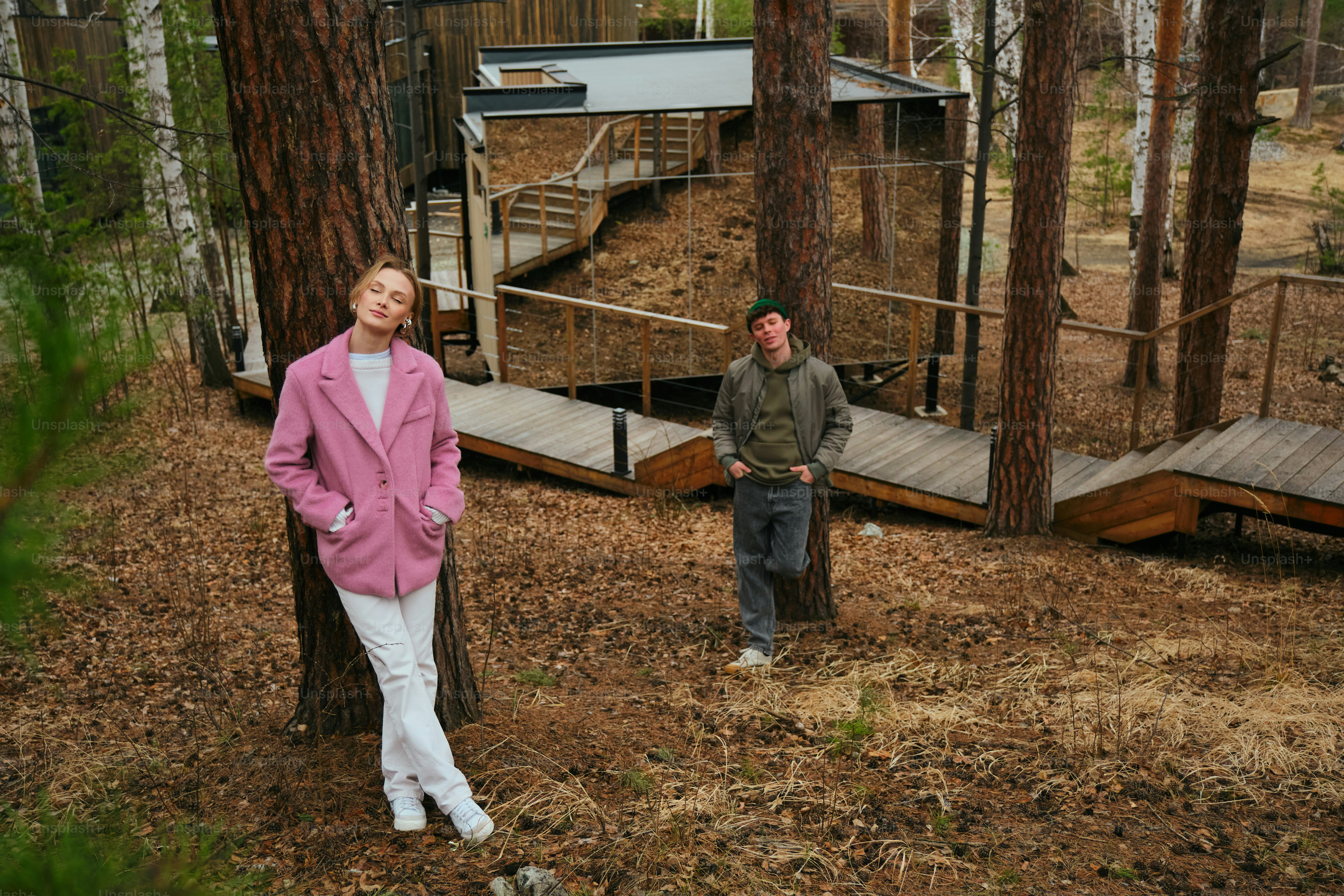 Two people pose next to trees in the forest. photo – Travel Image on ...