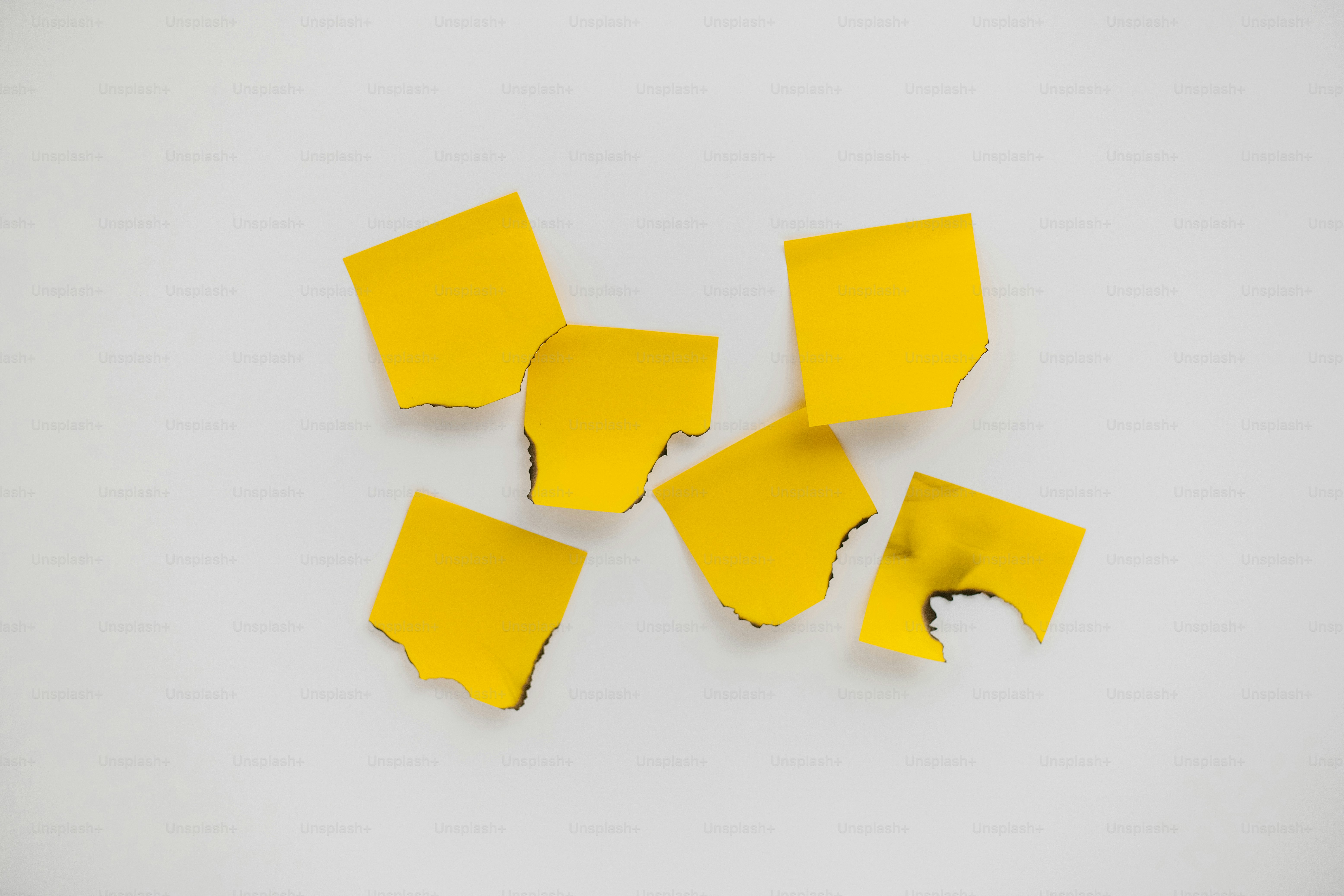 Yellow paper scraps are scattered on a white surface. photo – Burnout ...