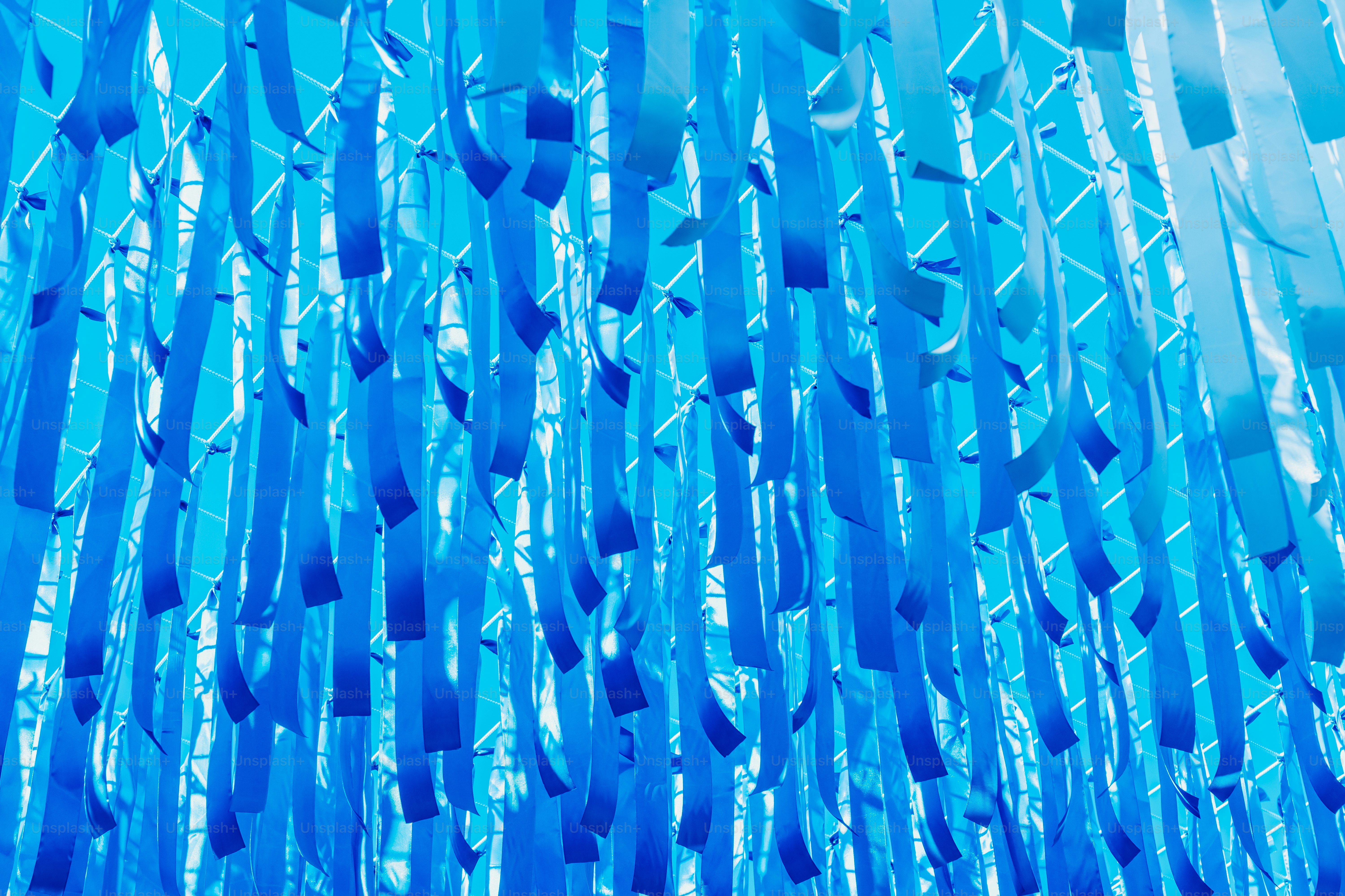 Blue ribbons hang from the ceiling. photo – Wallpaper Image on Unsplash