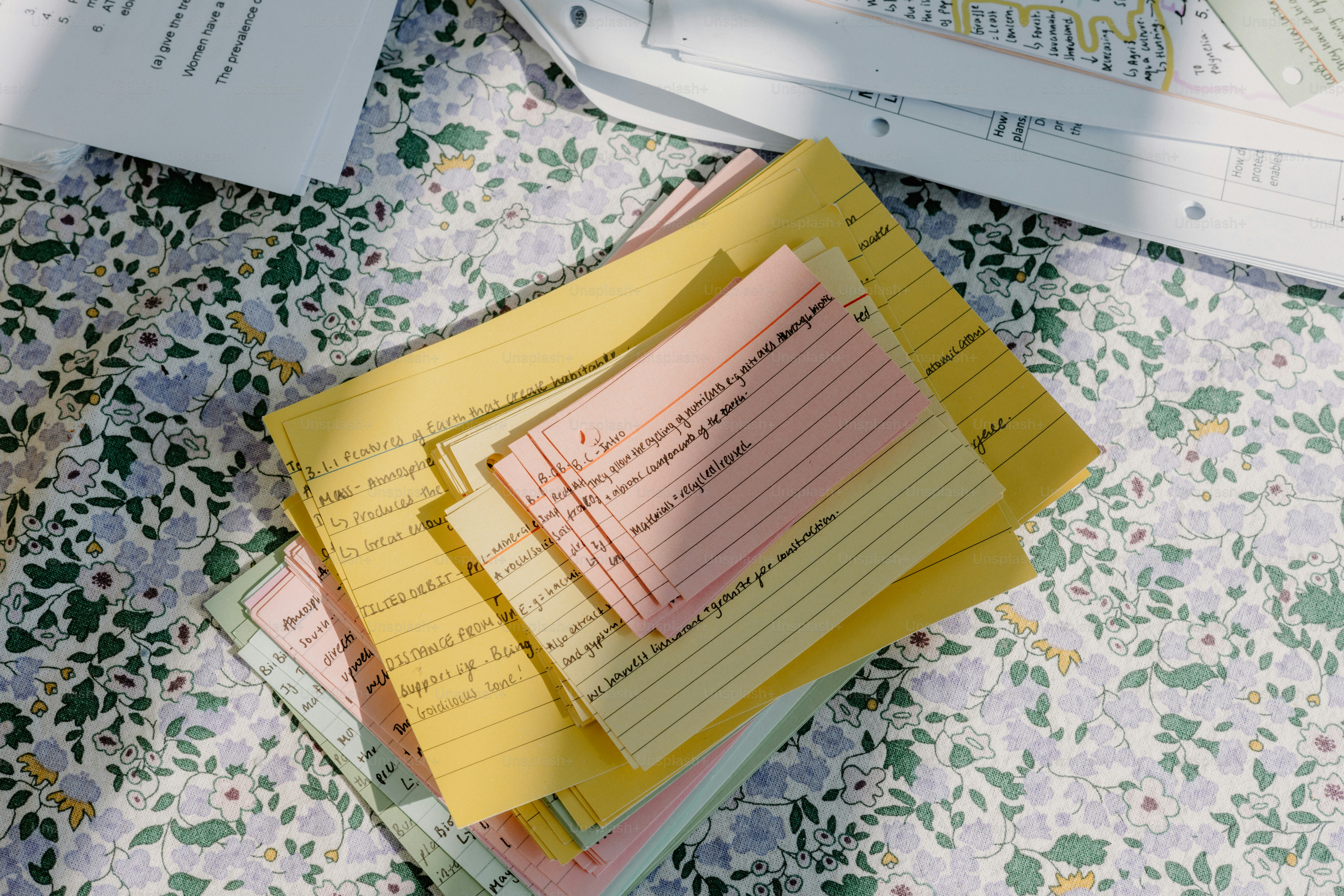 Pile of colorful sticky notes on a flowered surface. photo – Revision ...