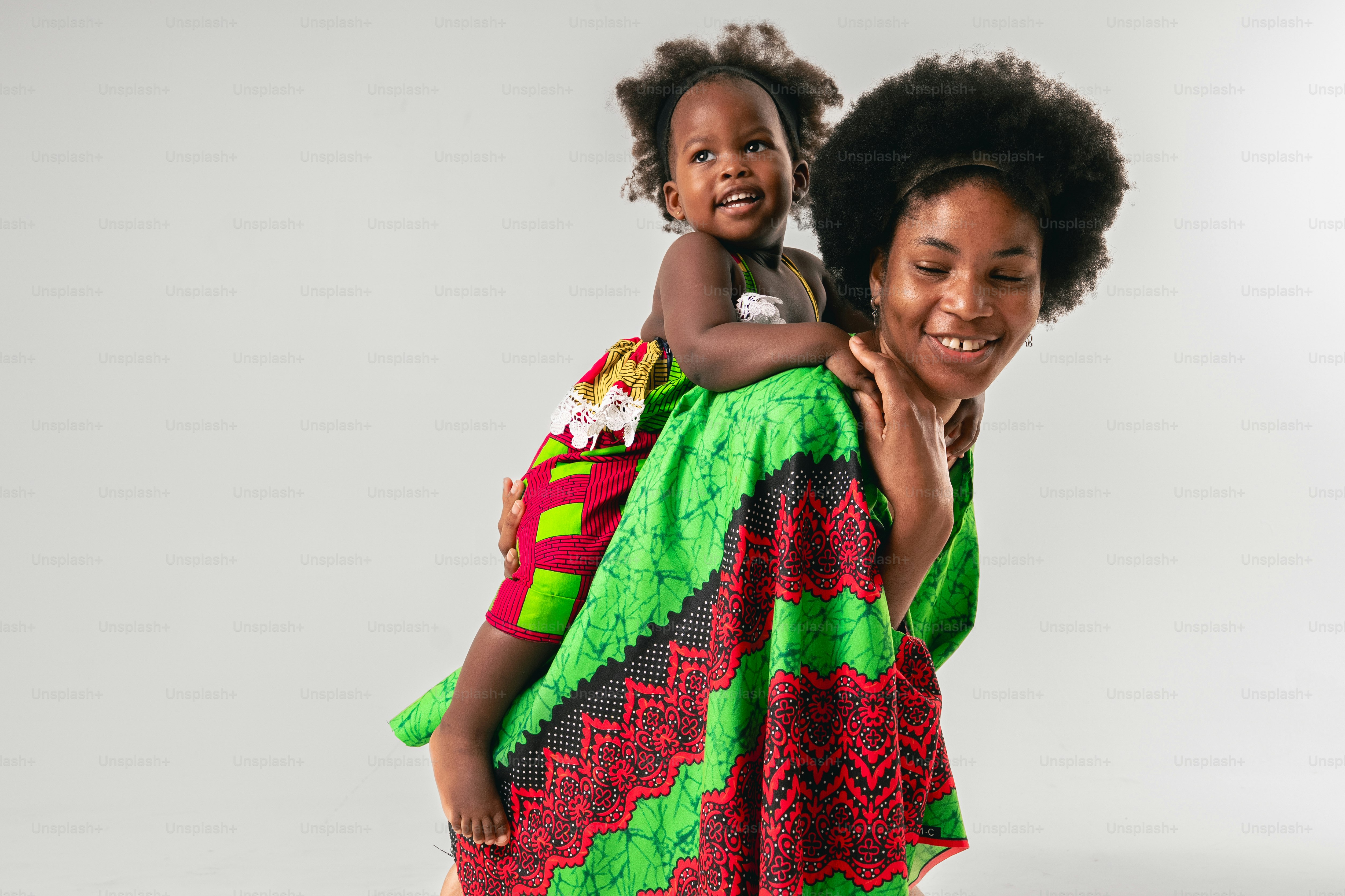 A smiling child in african attire looks upwards. photo – Happy family ...
