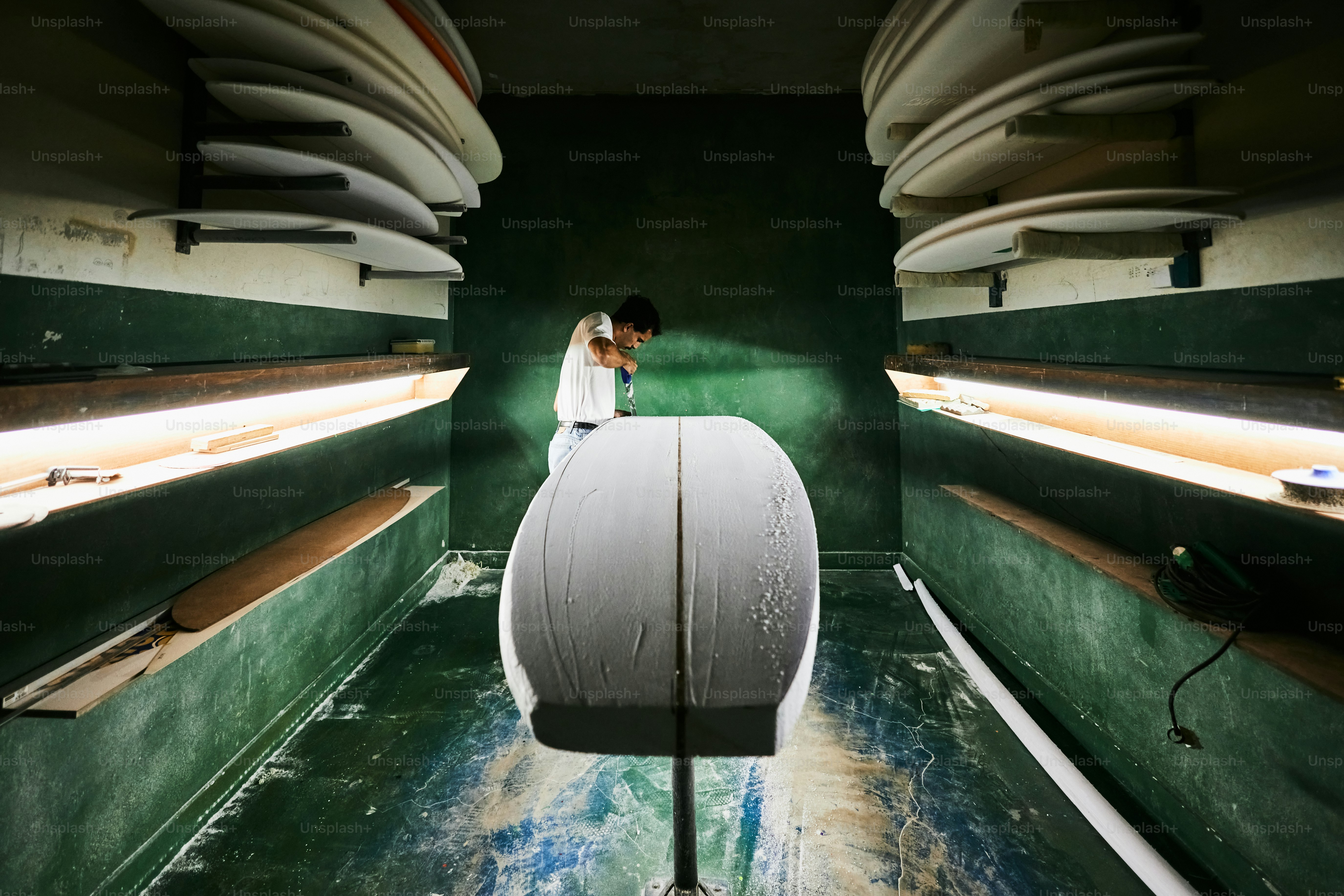 A surfboard shaper working in his workshop. photo – Workshop Image on ...
