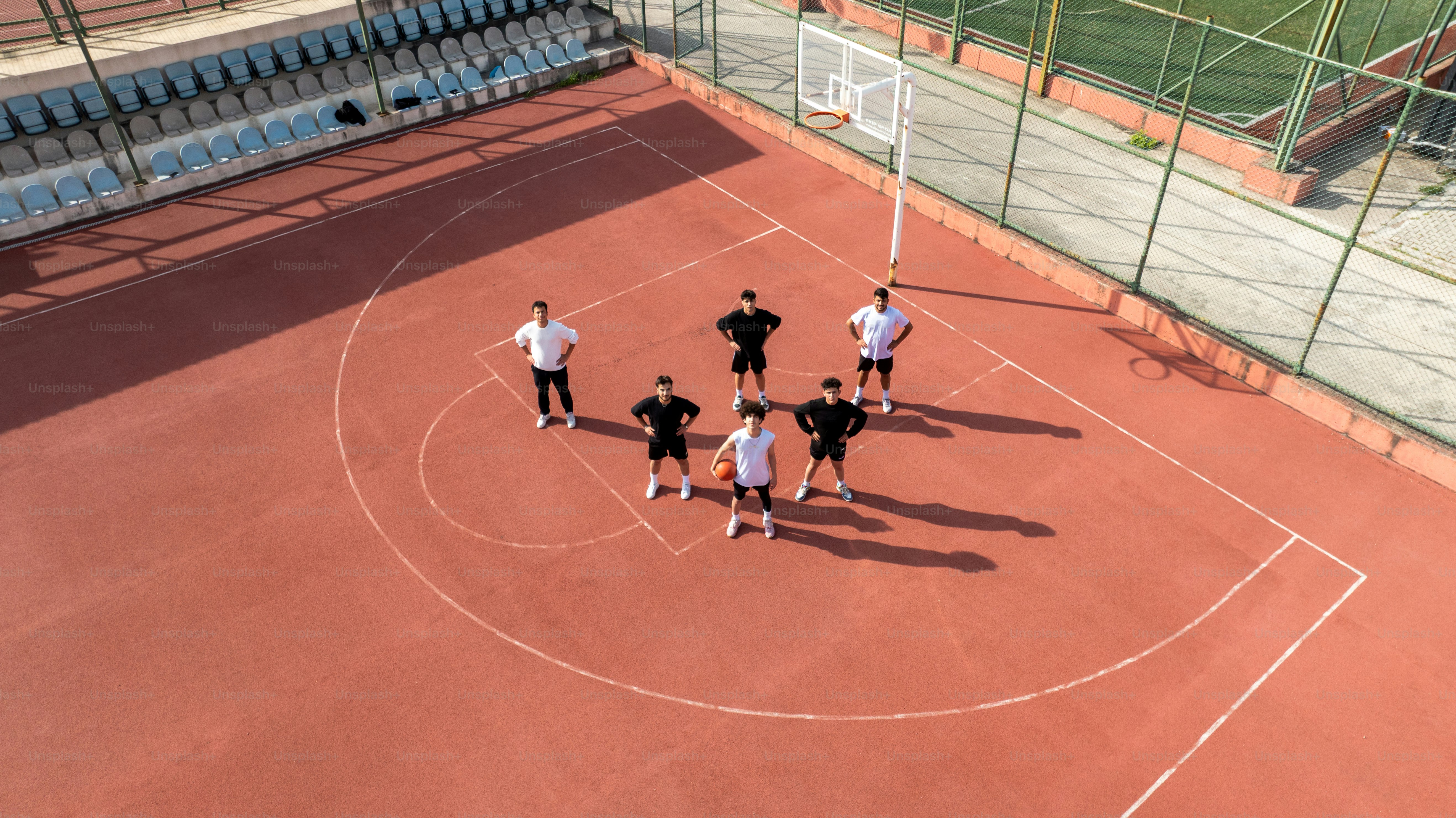Basketball players pose on the court. photo – Exercising Image on Unsplash