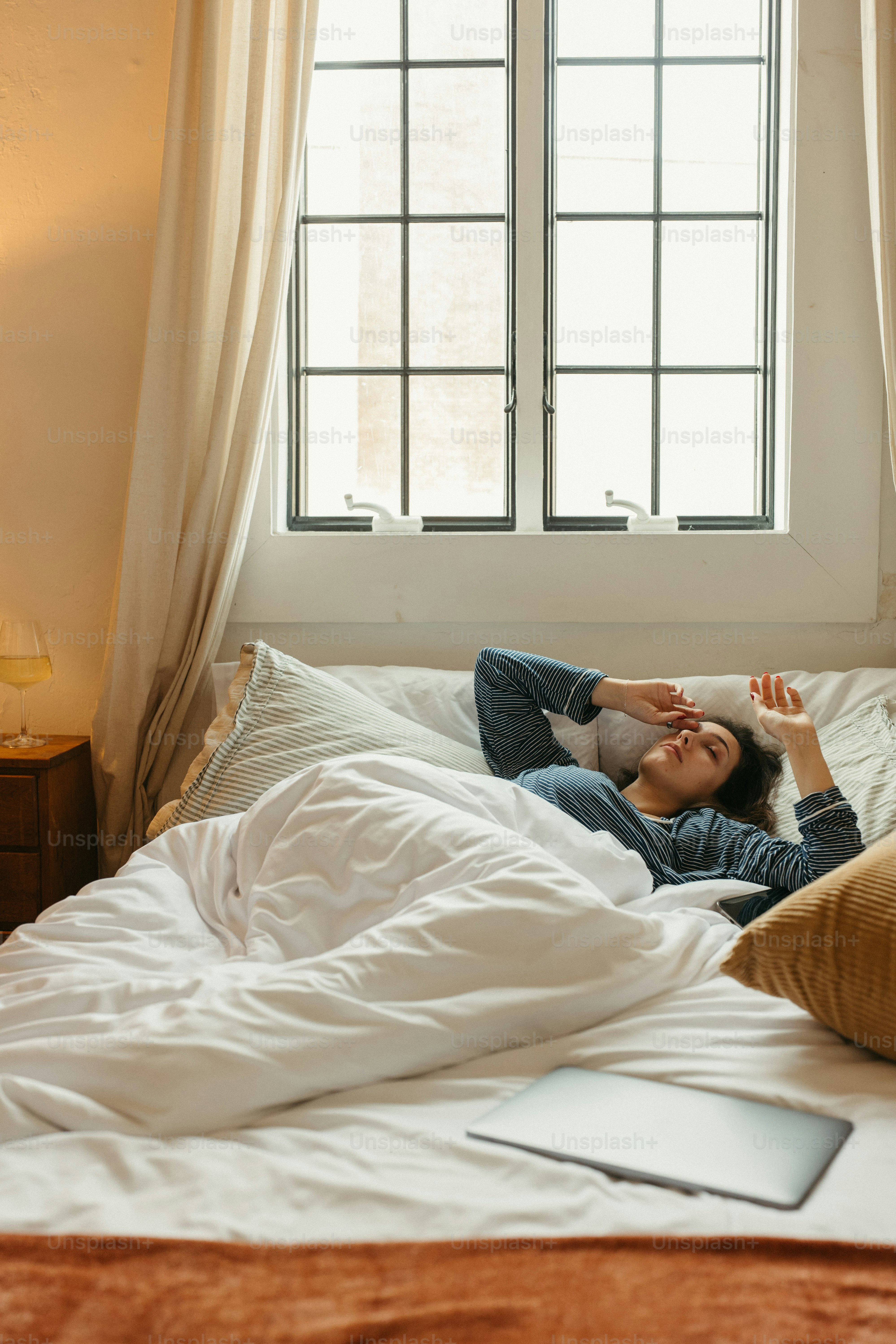 Woman waking up in bed, reaching for the sky. photo – Lazy Image on ...