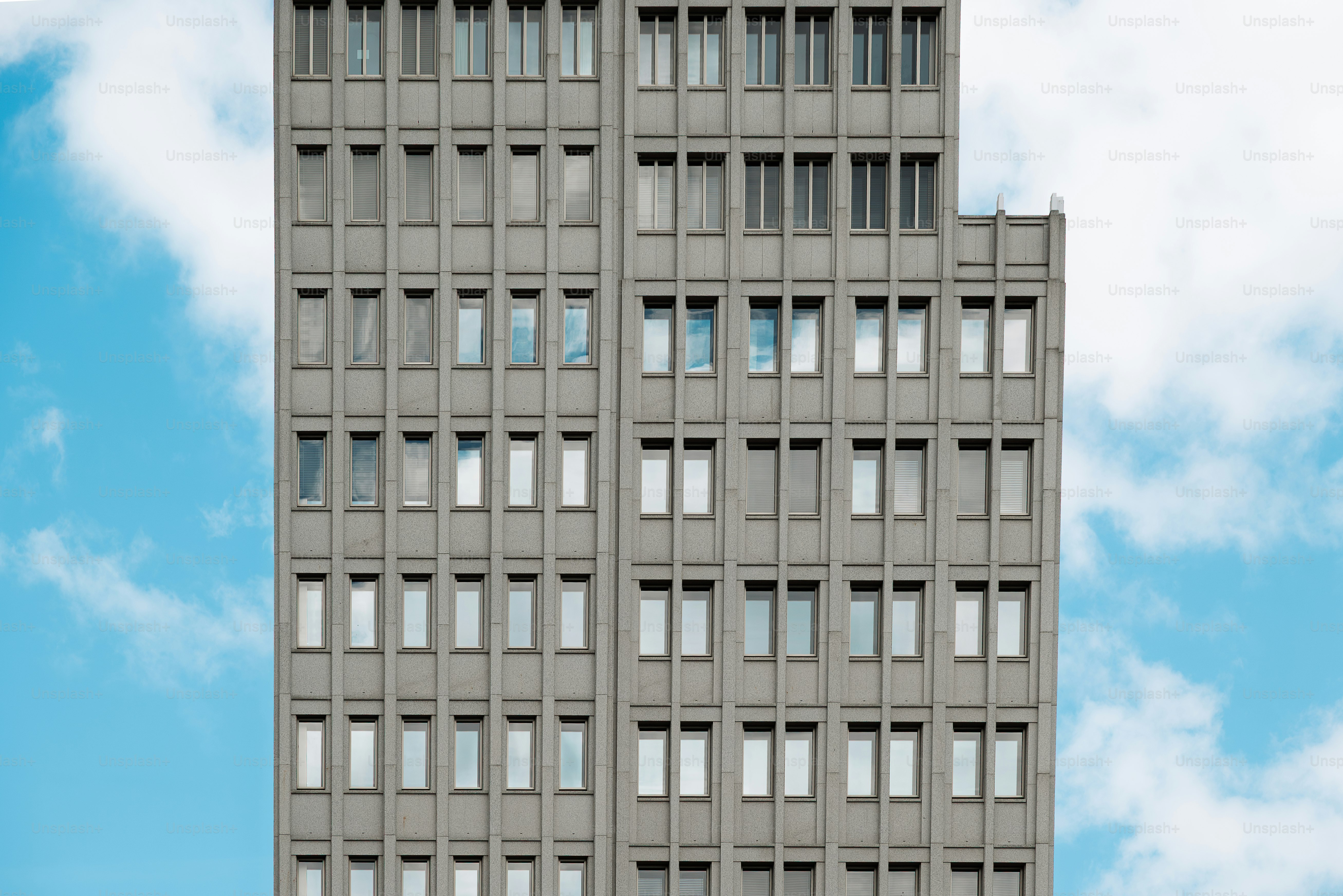 Gray skyscraper against a bright, blue sky. photo – Architecture Image ...