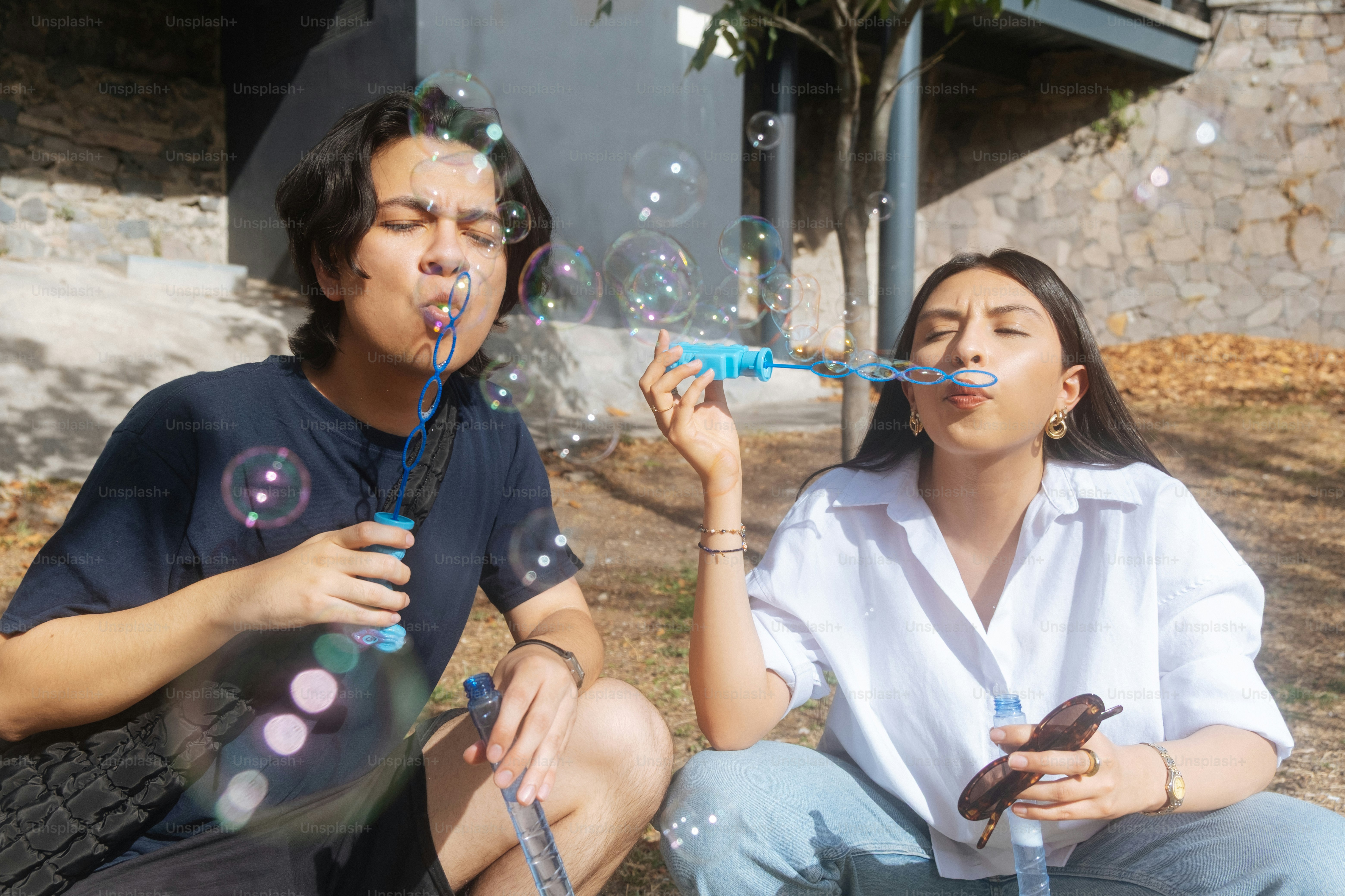 Two people blow bubbles outdoors in the sunshine. photo – Portrait ...