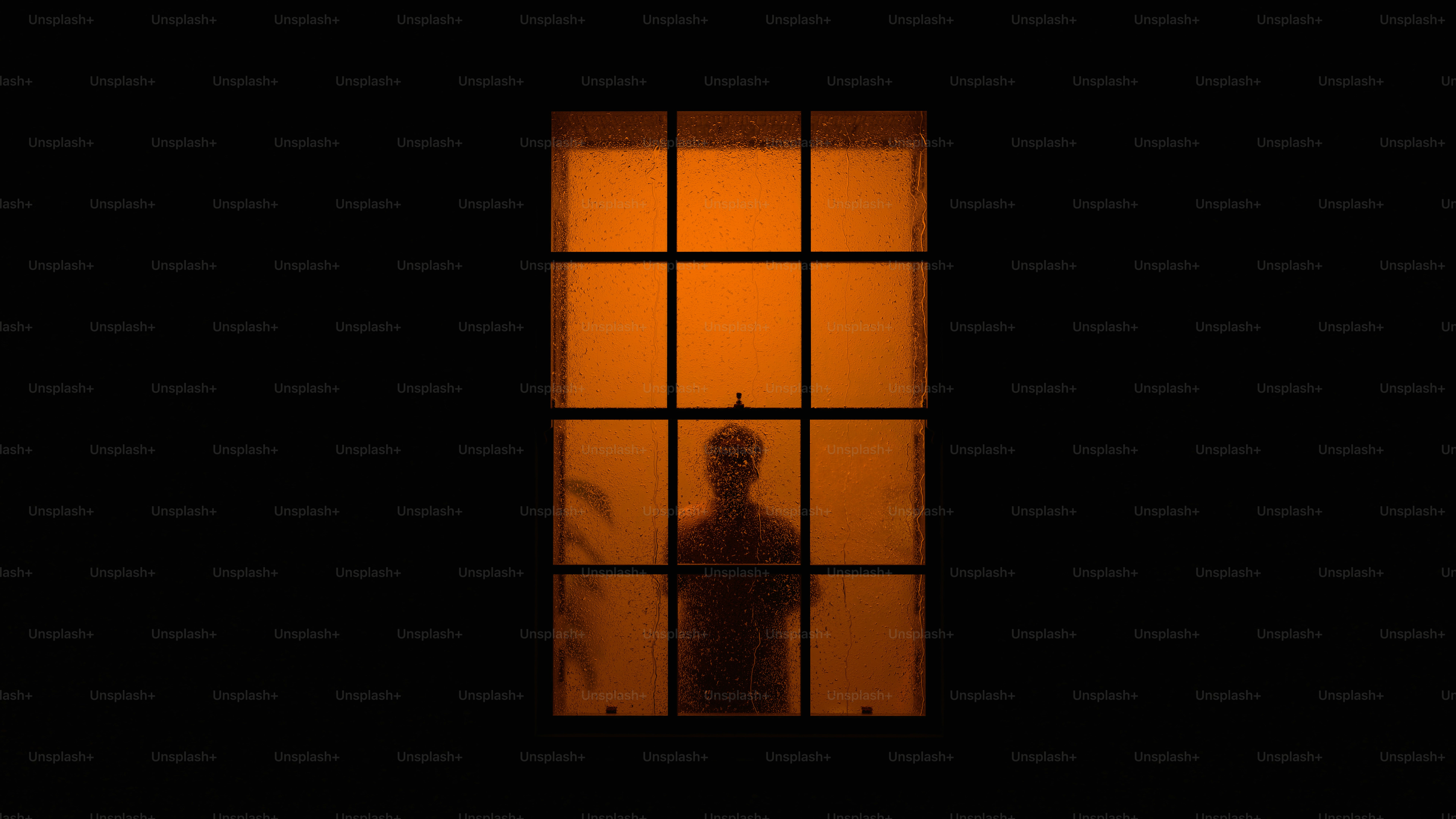 A silhouette stands inside an orange-lit window. photo – Night Image on ...