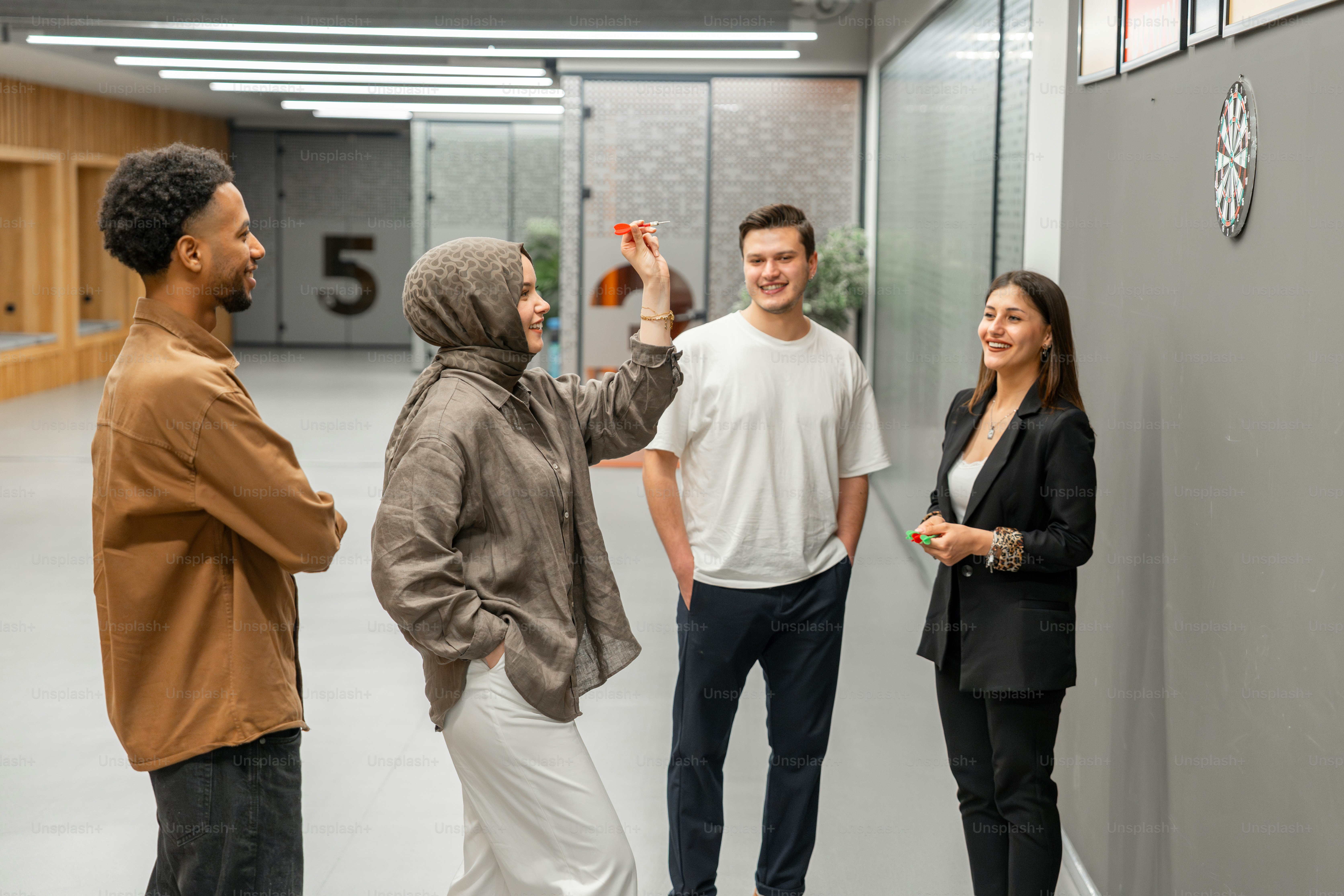 Four people celebrate and cheer inside a building. photo – Team Image ...