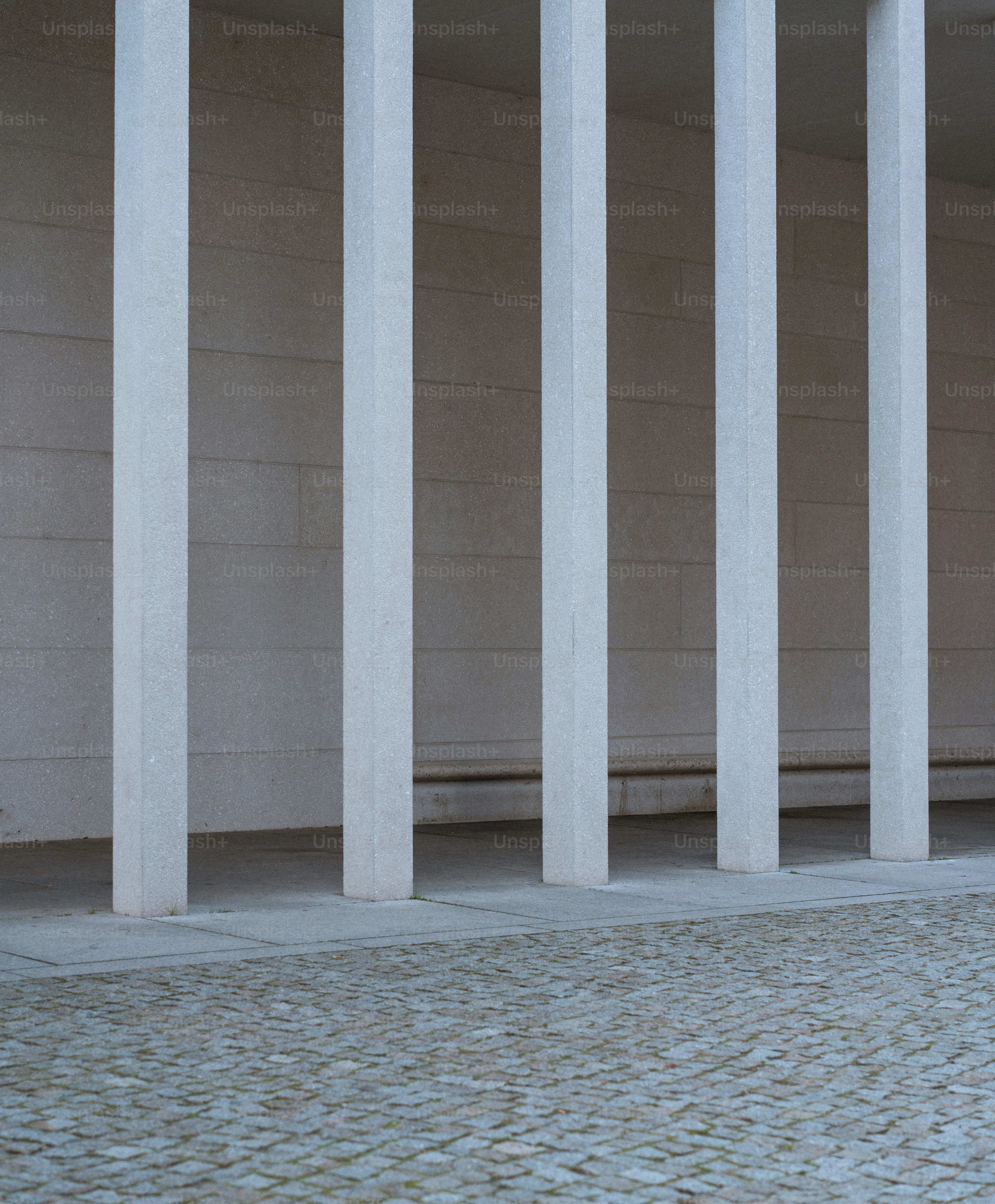 Six vertical columns stand before a stone floor. photo – Wallpaper ...