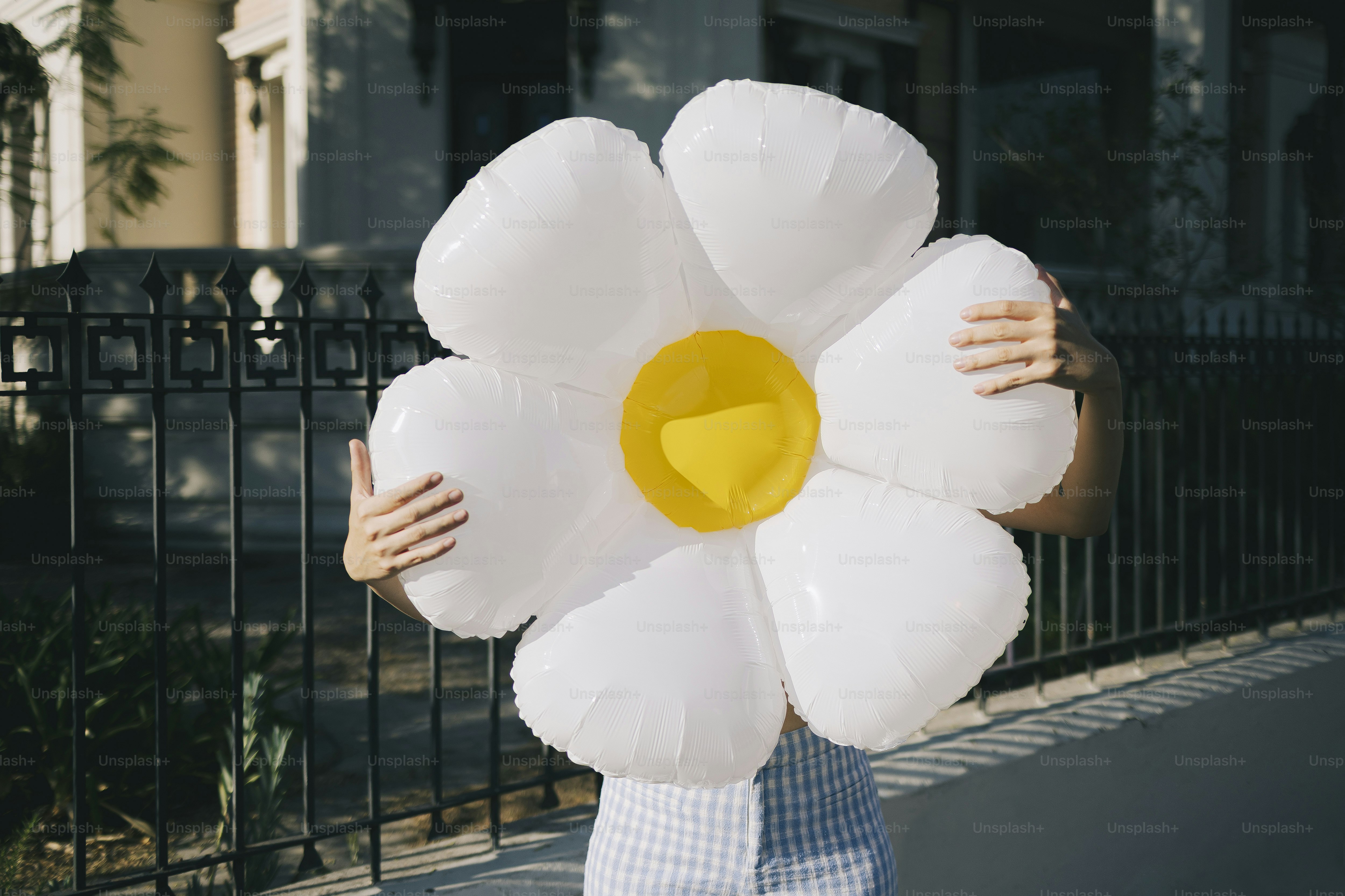 Someone is holding a giant inflatable flower. photo – Flower Image on ...