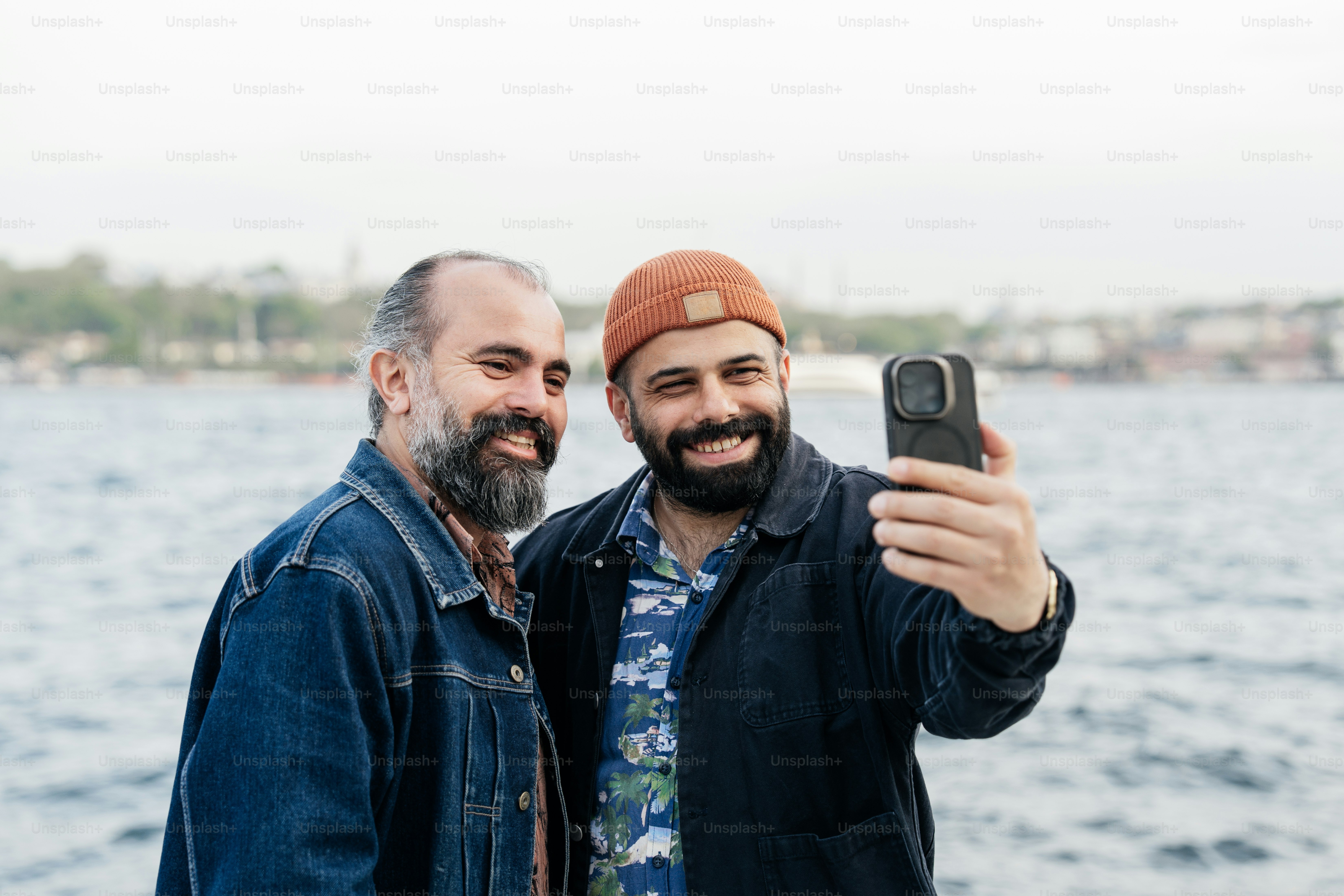 Two men take a selfie by the water. photo – Family Image on Unsplash