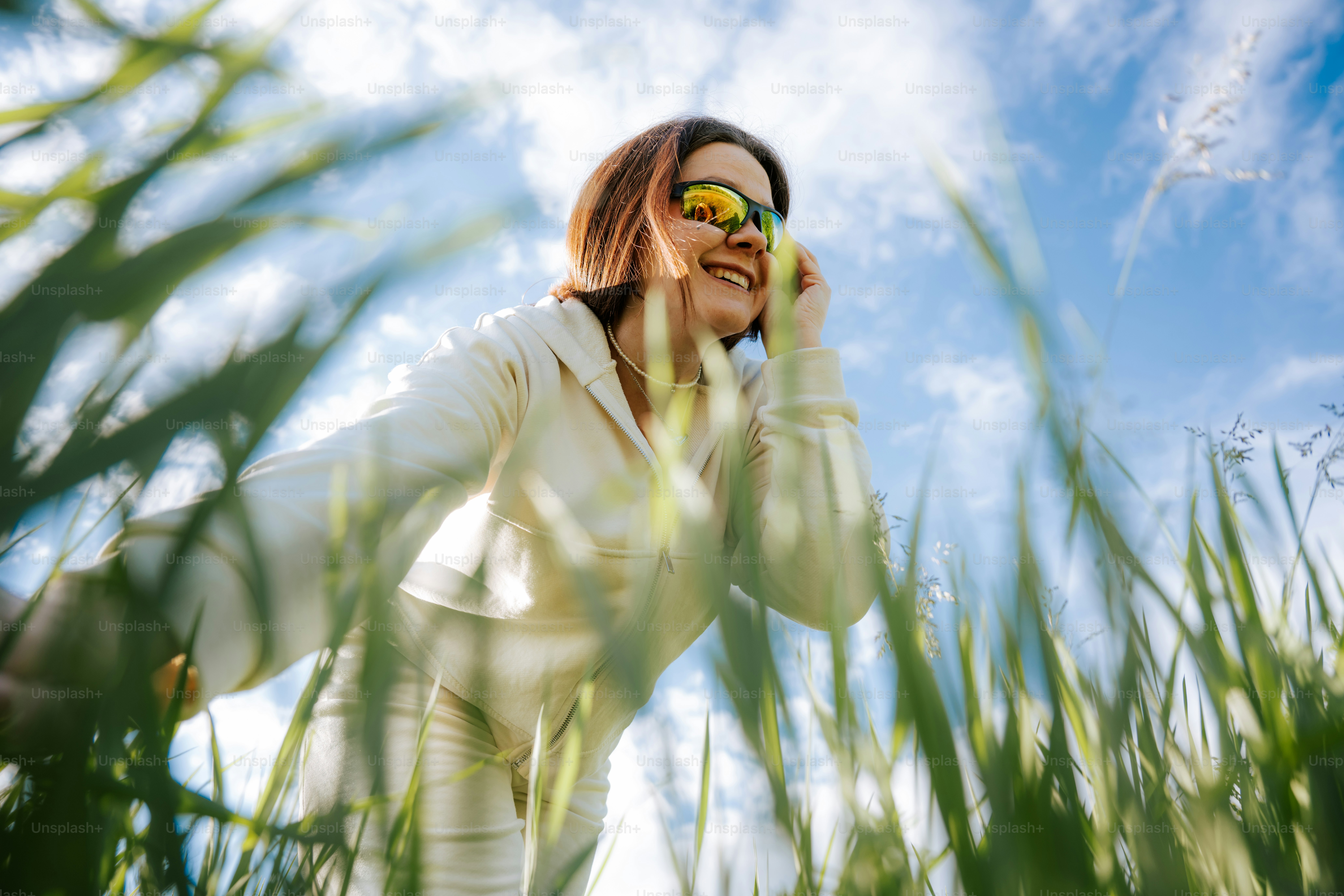 Woman smiles while talking on the phone outdoors. photo – Perspective ...