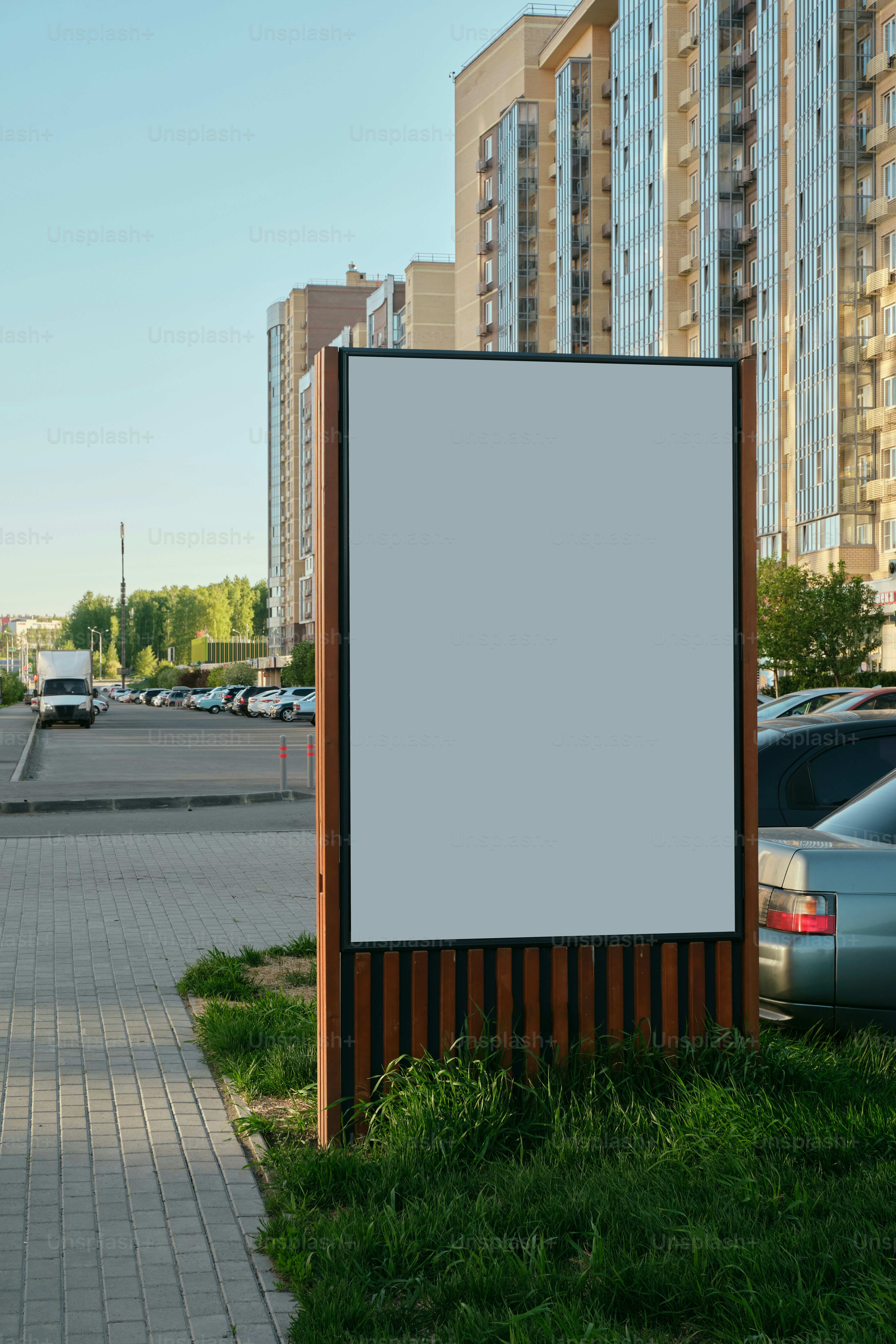 Blank billboard stands outside near buildings and parked cars. photo ...