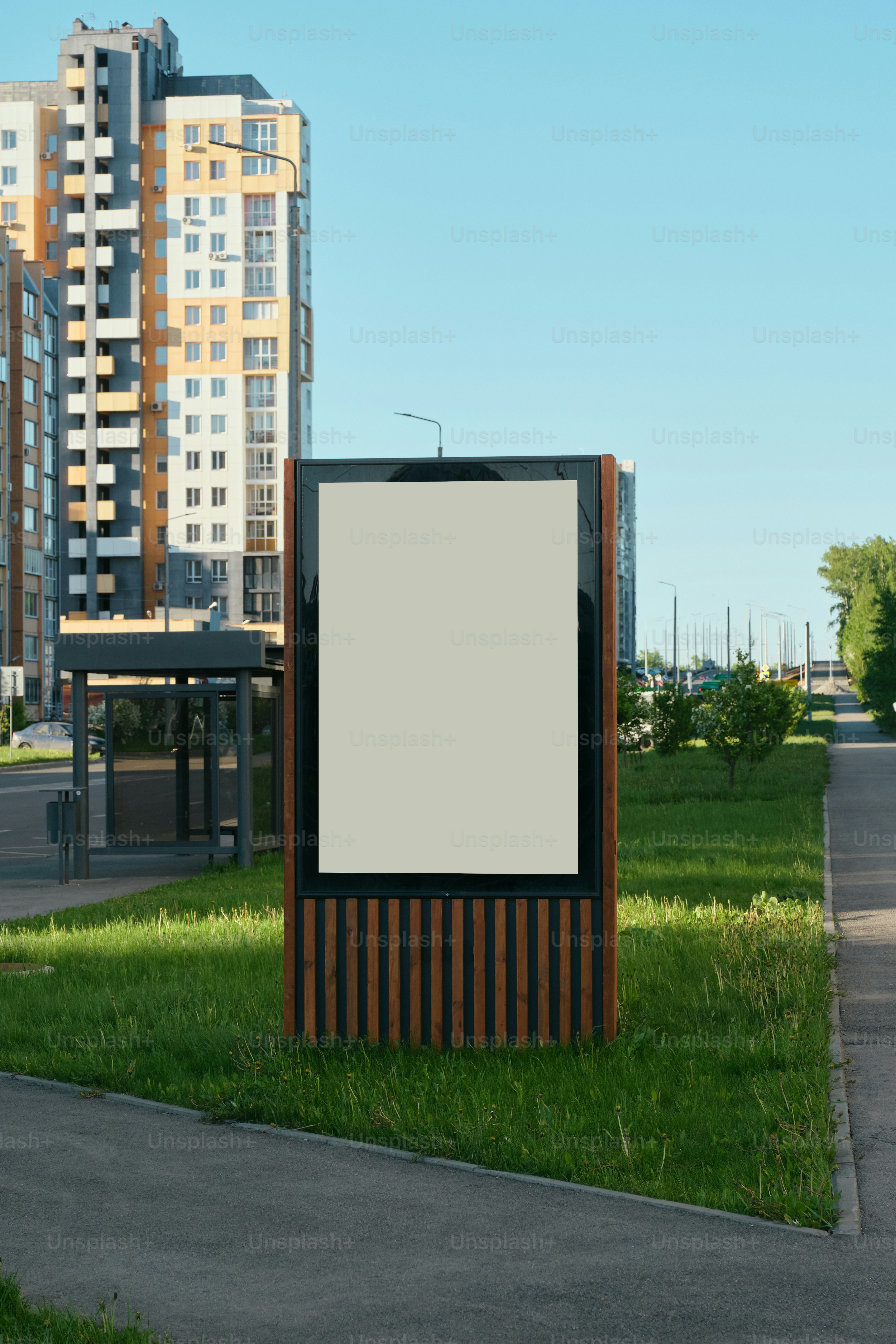 Billboard stands on a sidewalk with buildings in background. photo ...
