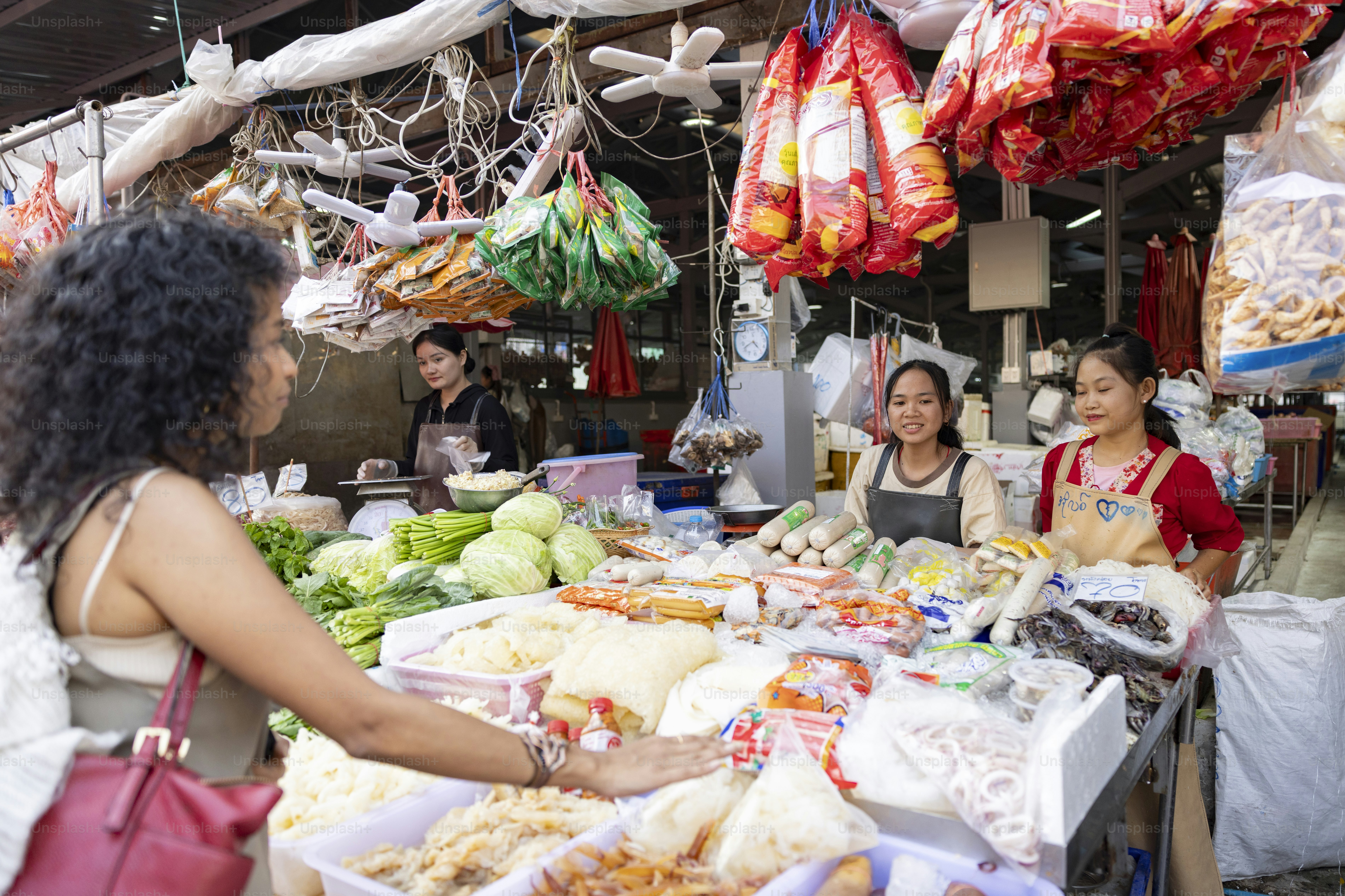 A woman shops at a busy outdoor market. photo – Food Image on Unsplash