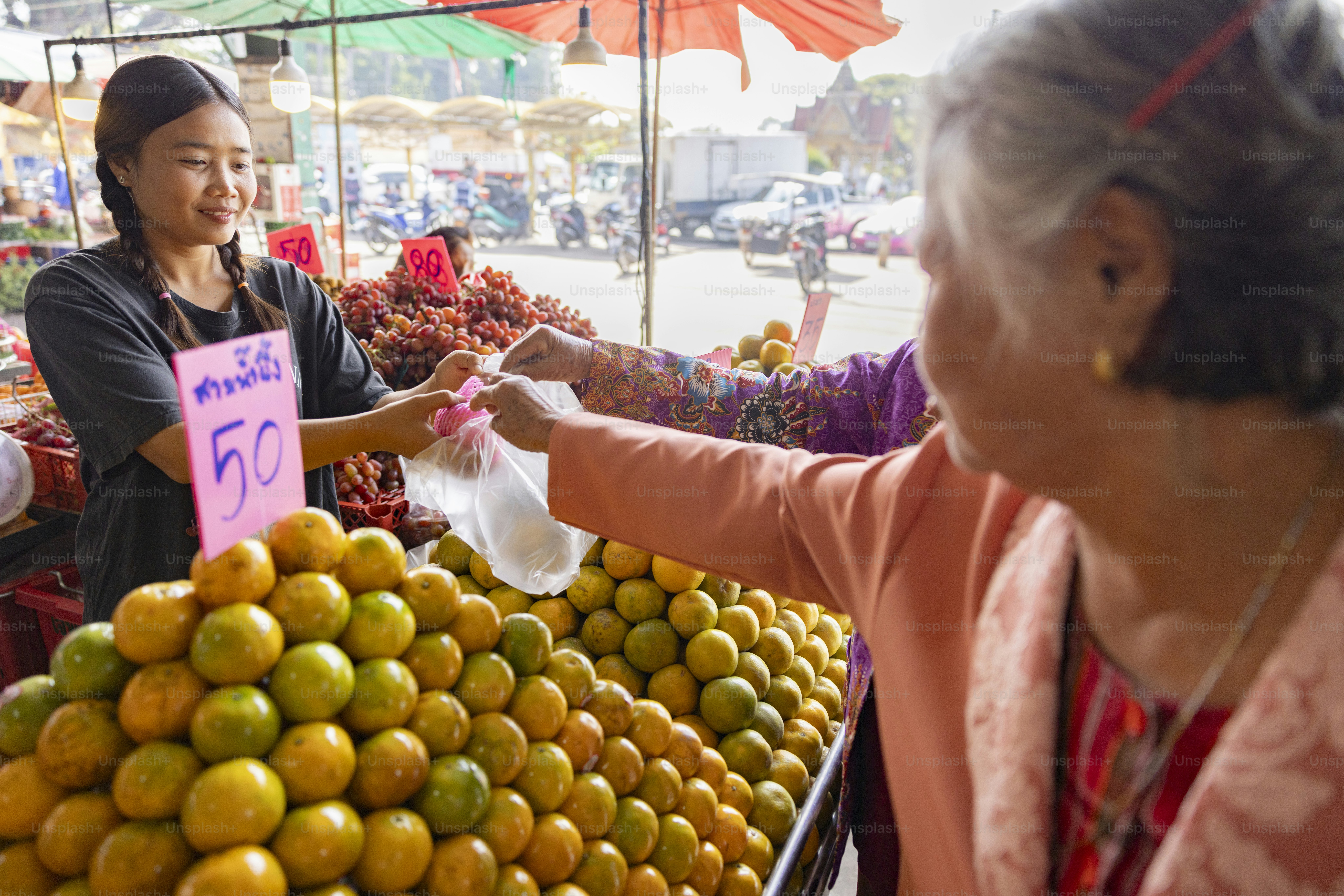 A vendor is selling oranges to a customer. photo – Food Image on Unsplash