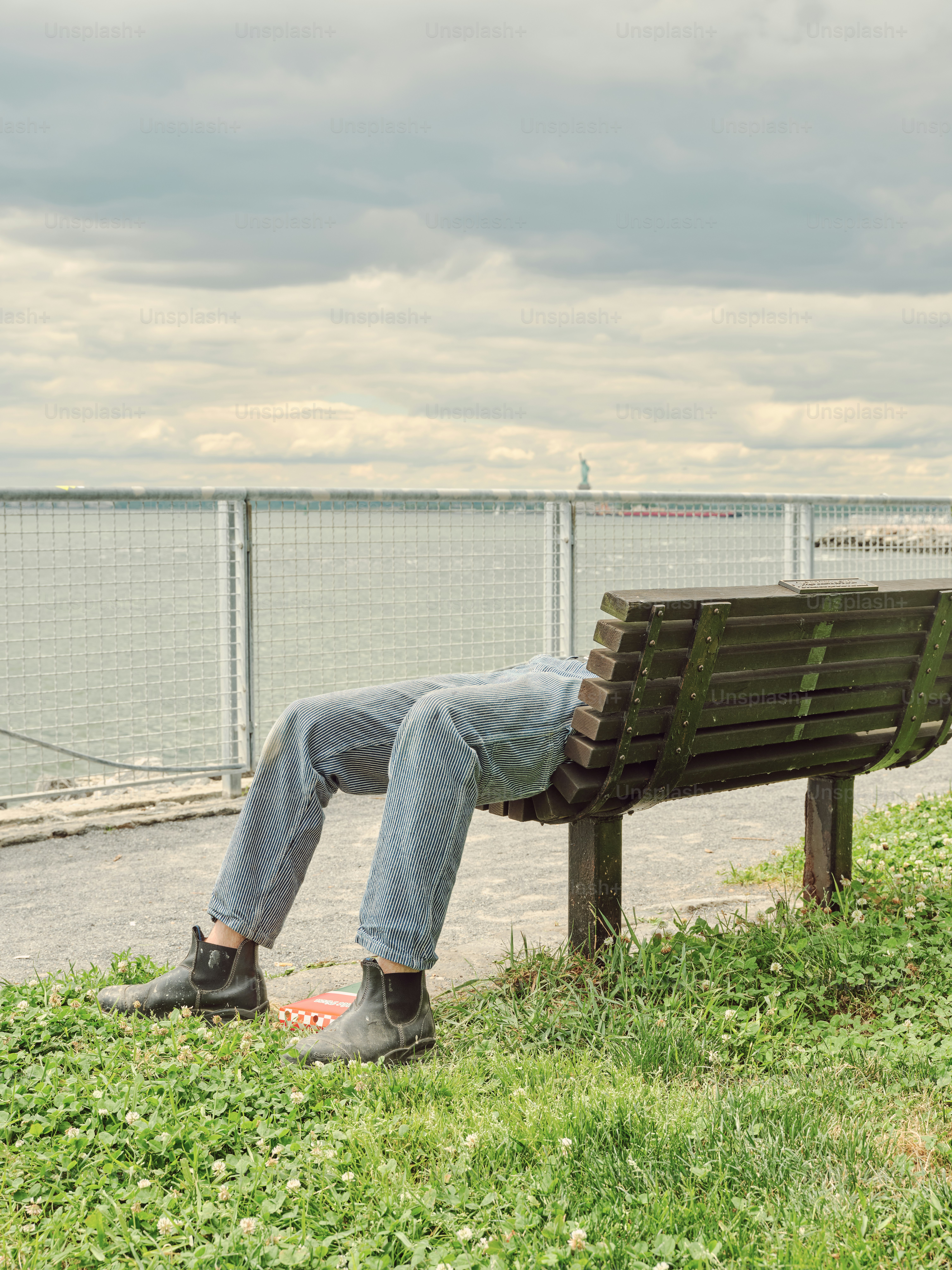 A person is concealed behind a bench. photo – City Image on Unsplash