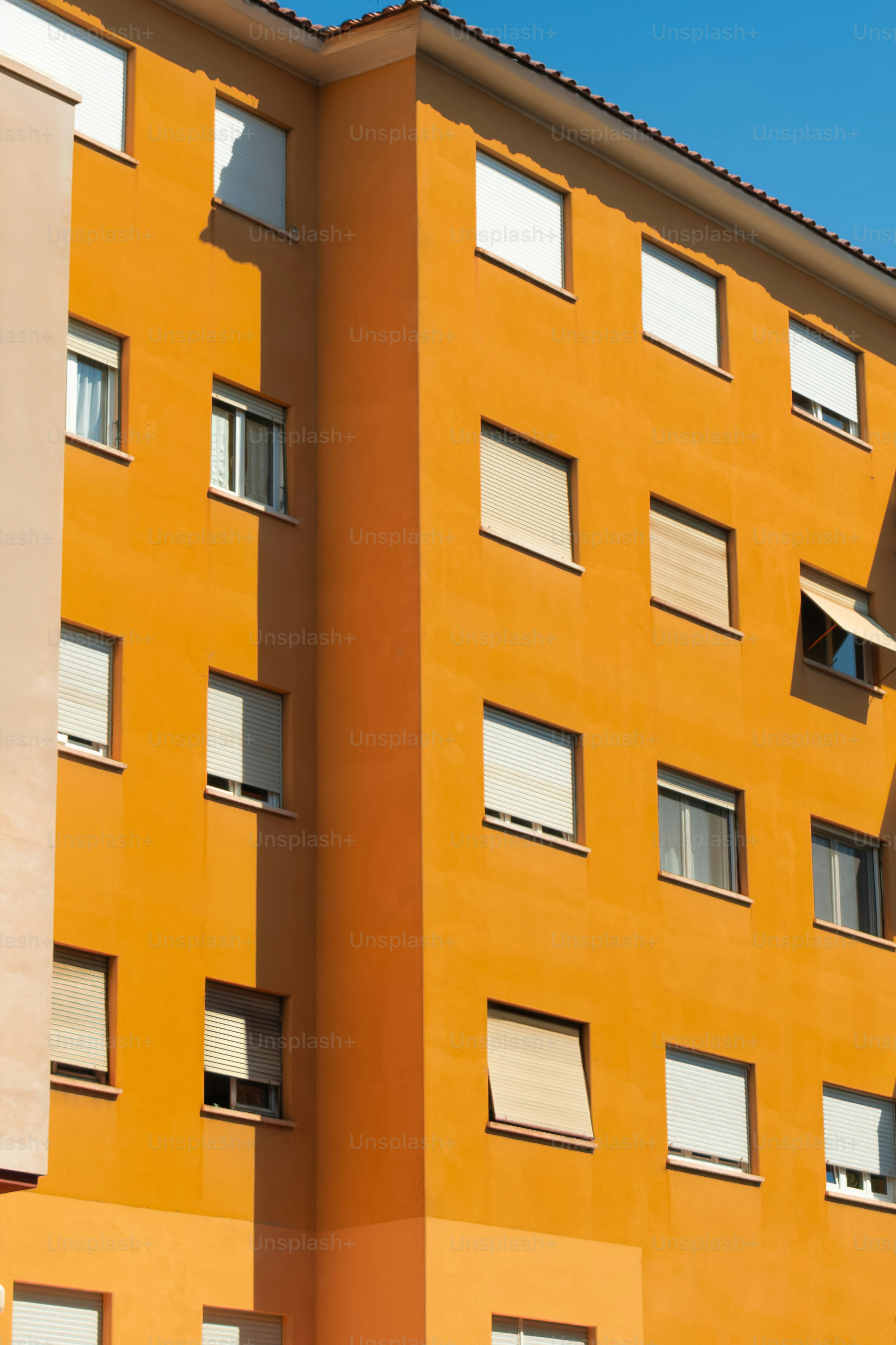 A bright orange building with many windows. photo – Architecture Image ...