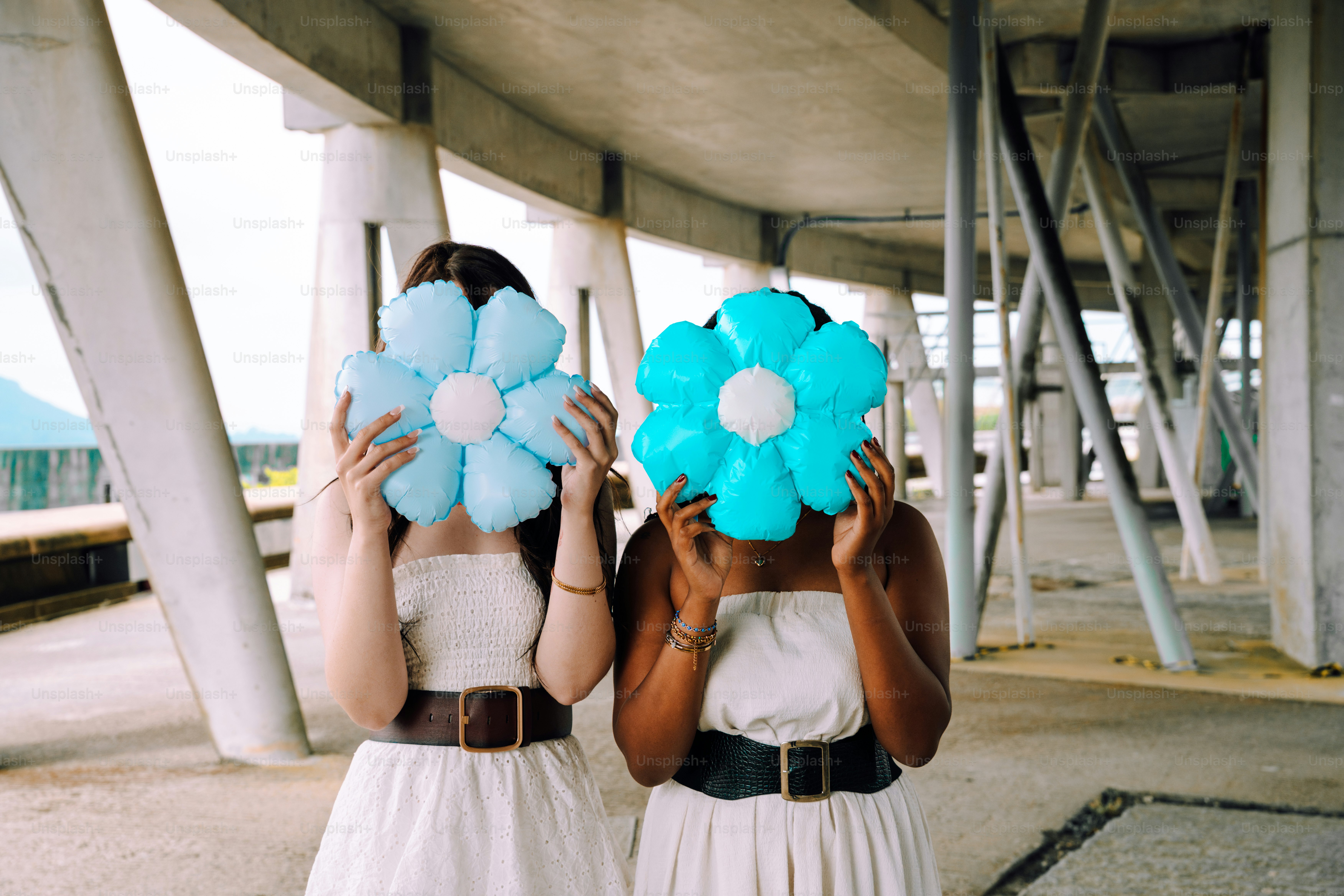 Two women run with balloons underneath a bridge. photo – Flower Image ...