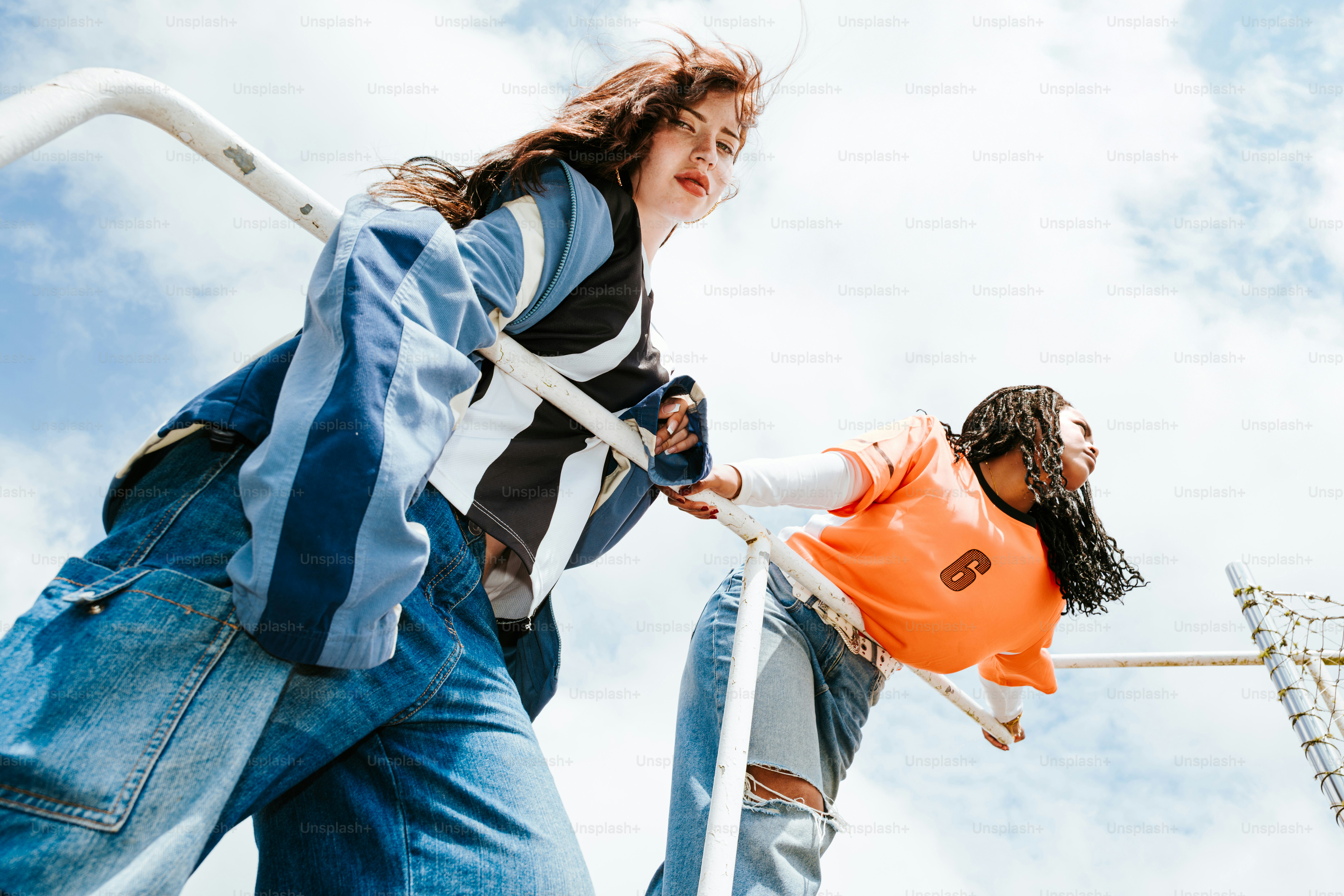 Two people are leaning over a railing. photo – Fashion Image on Unsplash