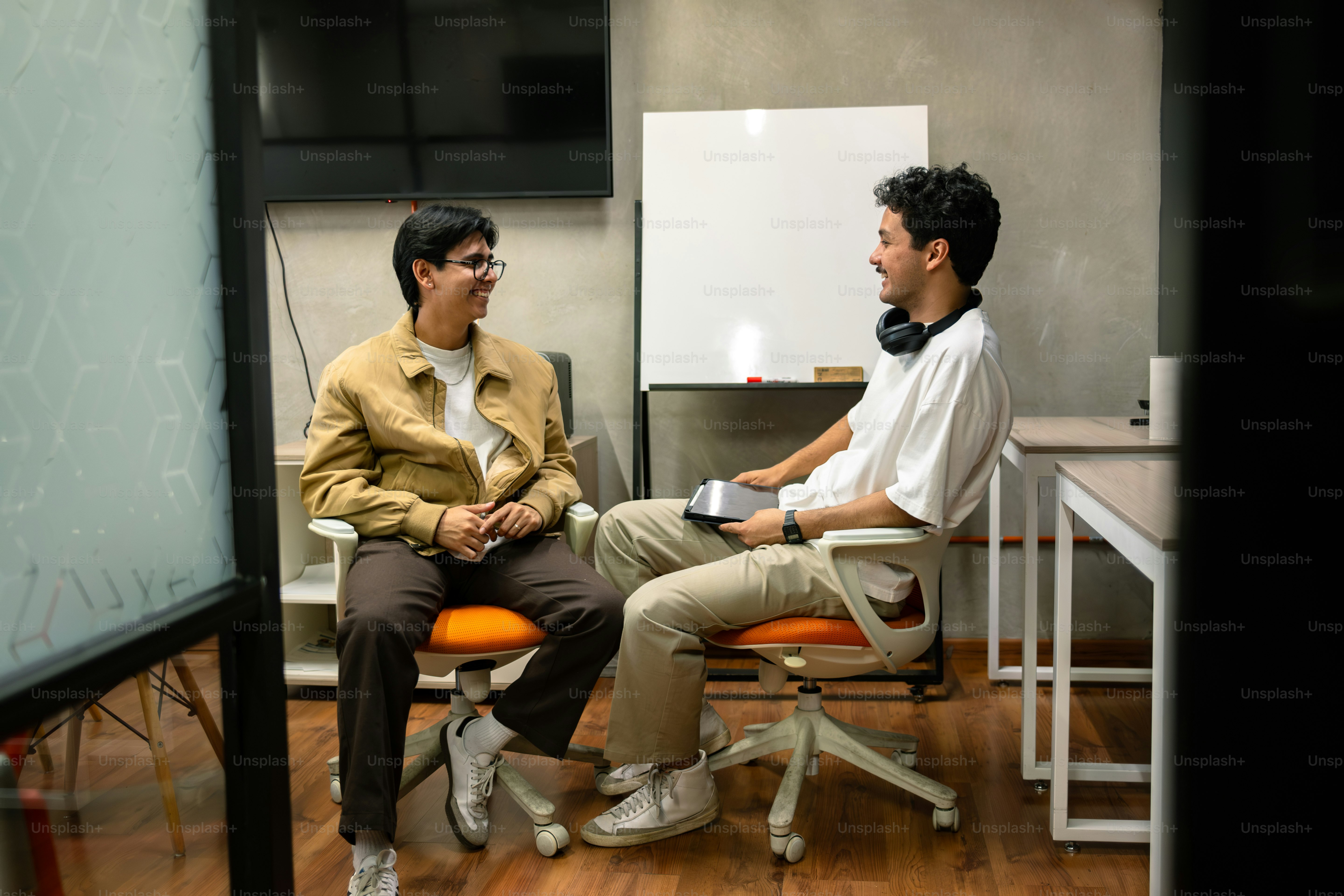Two men smile while having a conversation. photo – Team Image on Unsplash