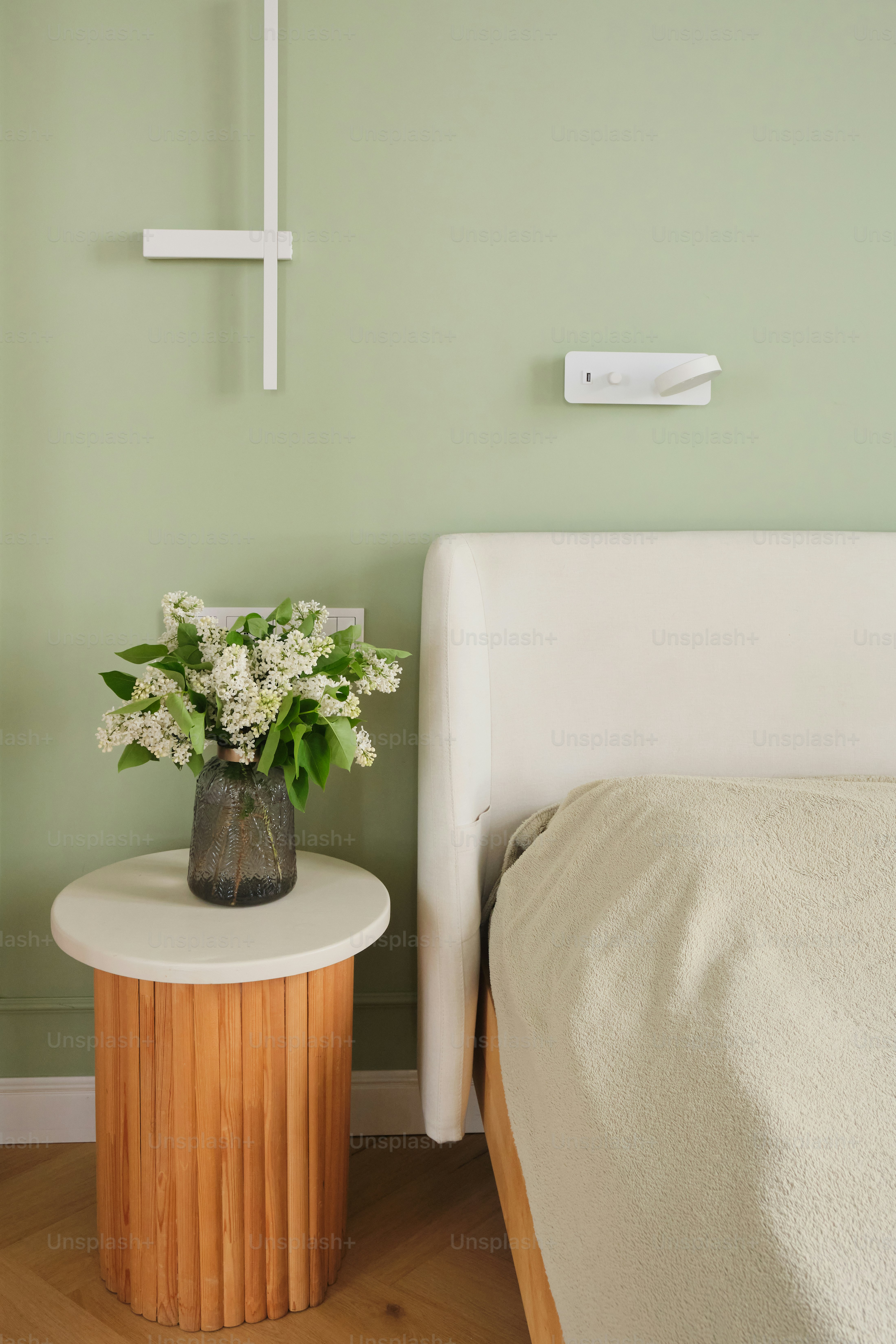 A bedroom with flowers on a bedside table. photo – Architecture Image ...