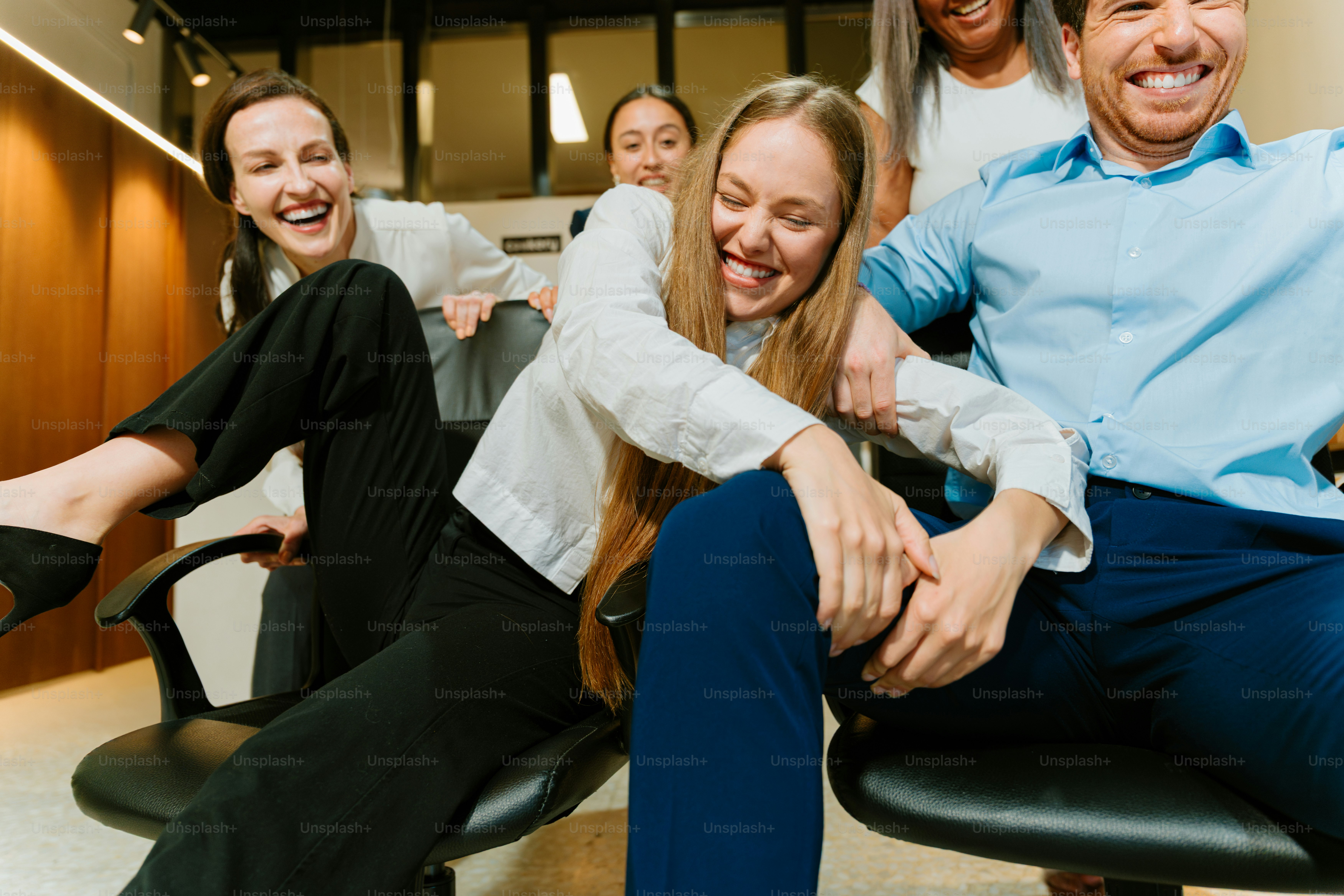 Office workers have fun racing in chairs. photo – Team Image on Unsplash