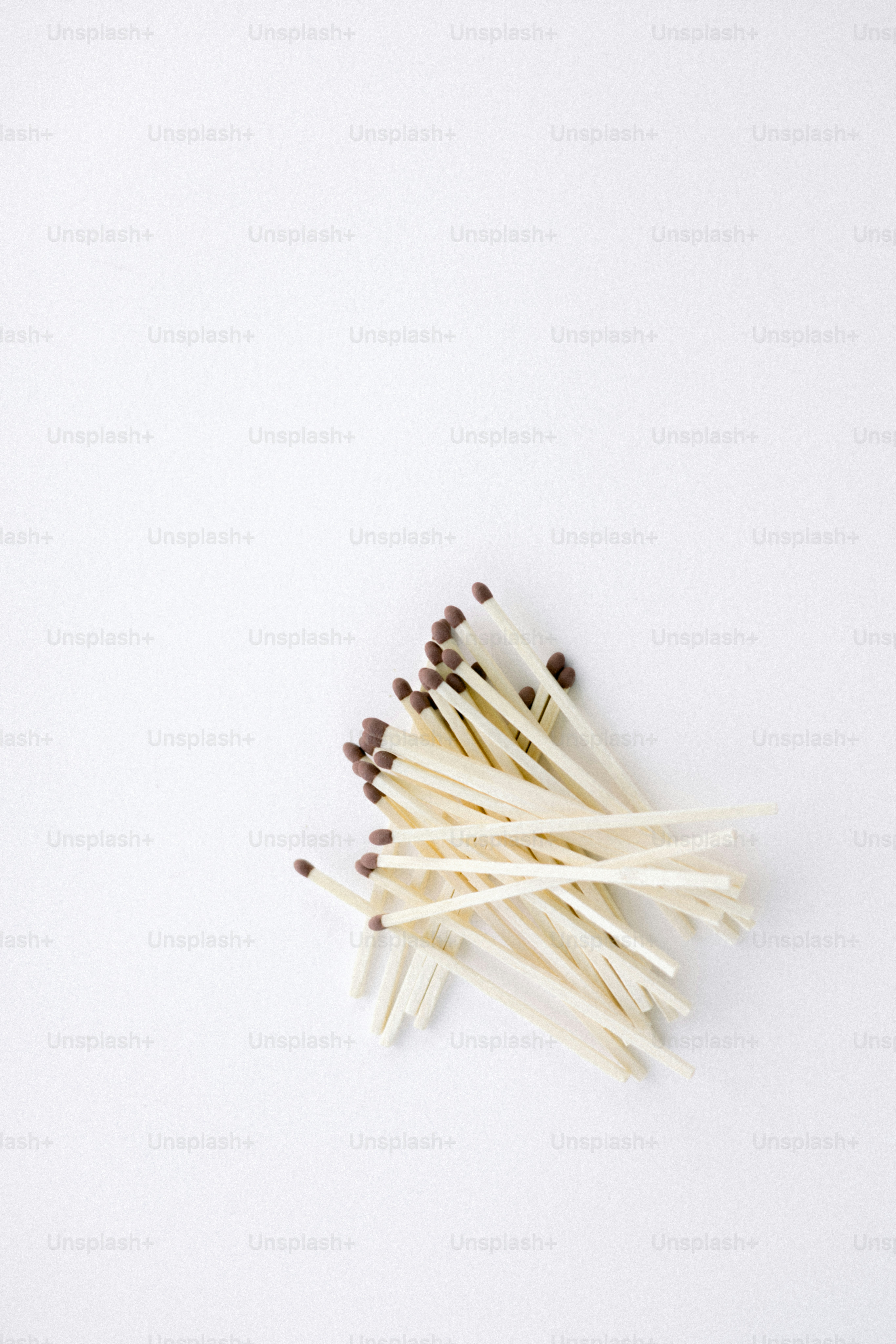 A small pile of matches on a white surface. photo – Minimal Image on ...