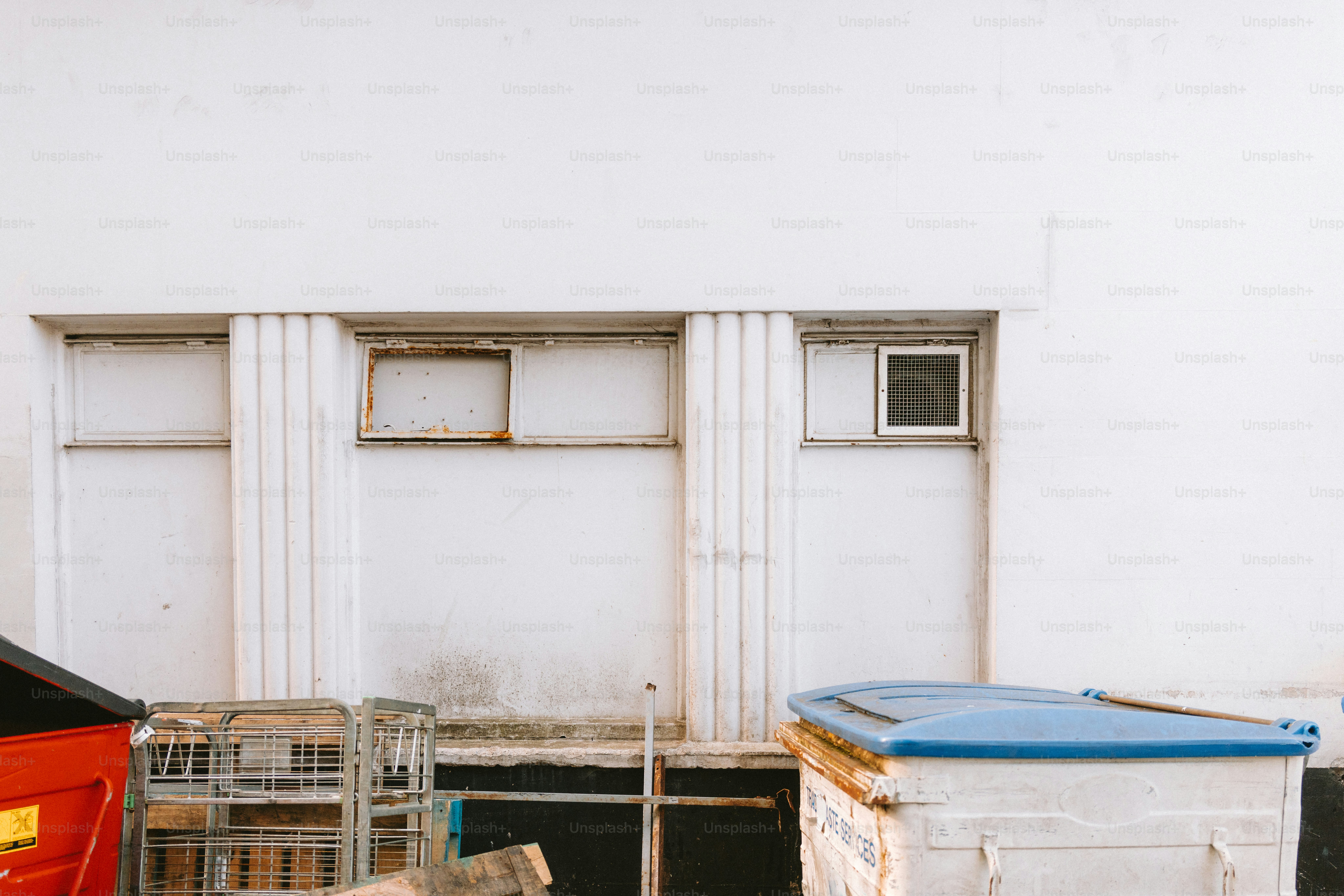 Exterior of a building with windows and trash. photo – Architecture ...