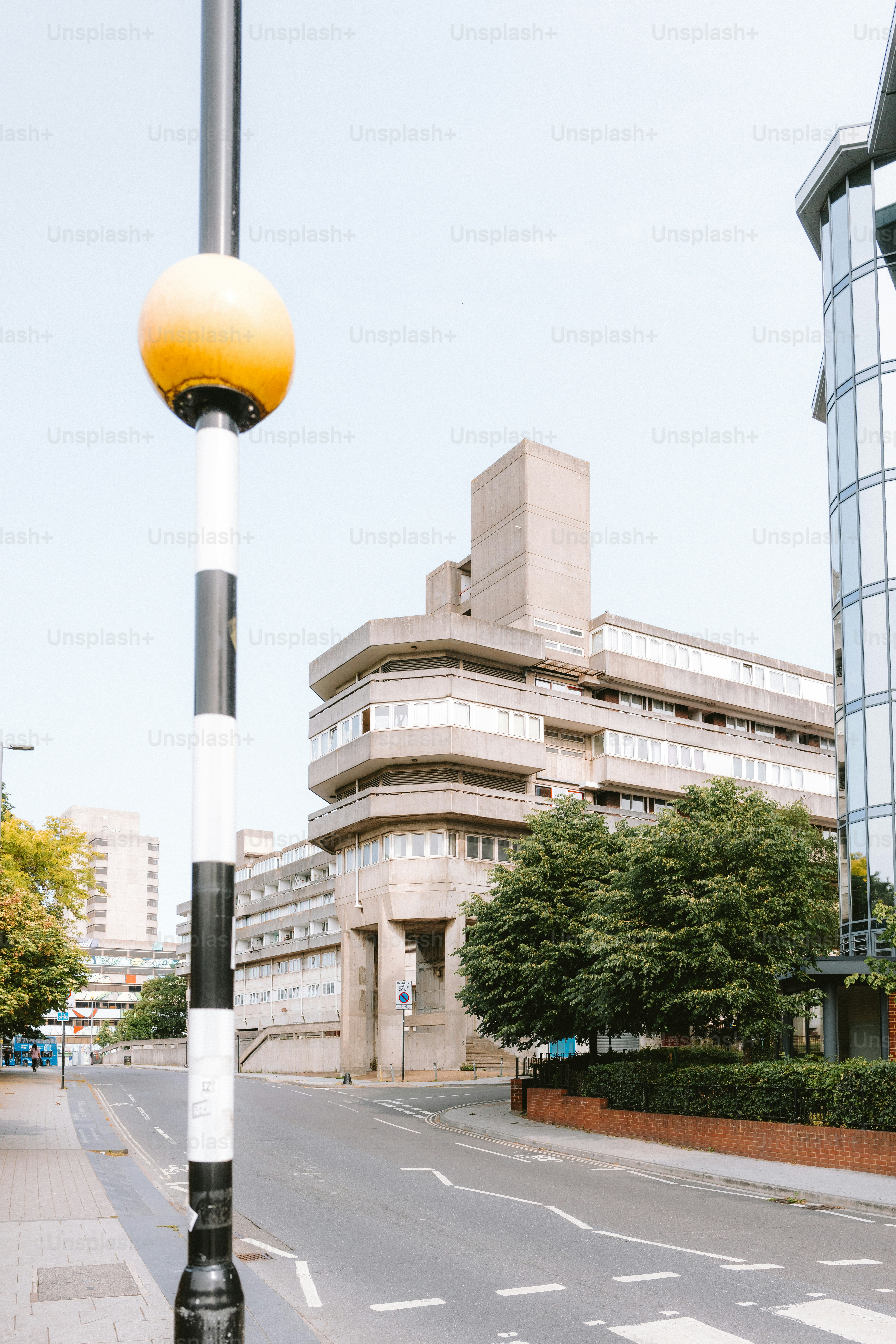 A street view with a large concrete building. photo – Architecture ...
