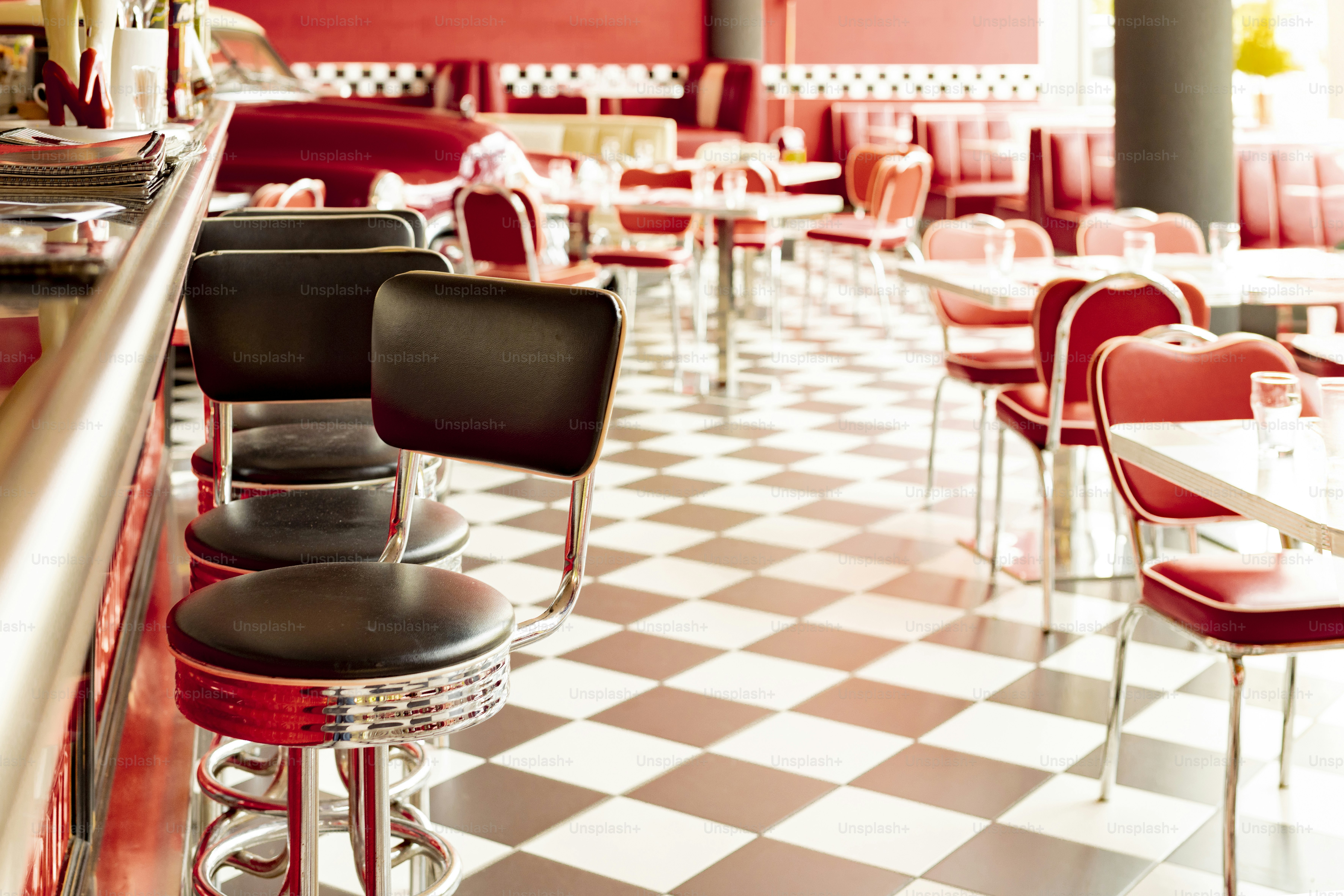 Classic diner interior with checkerboard floor and red seating. photo ...