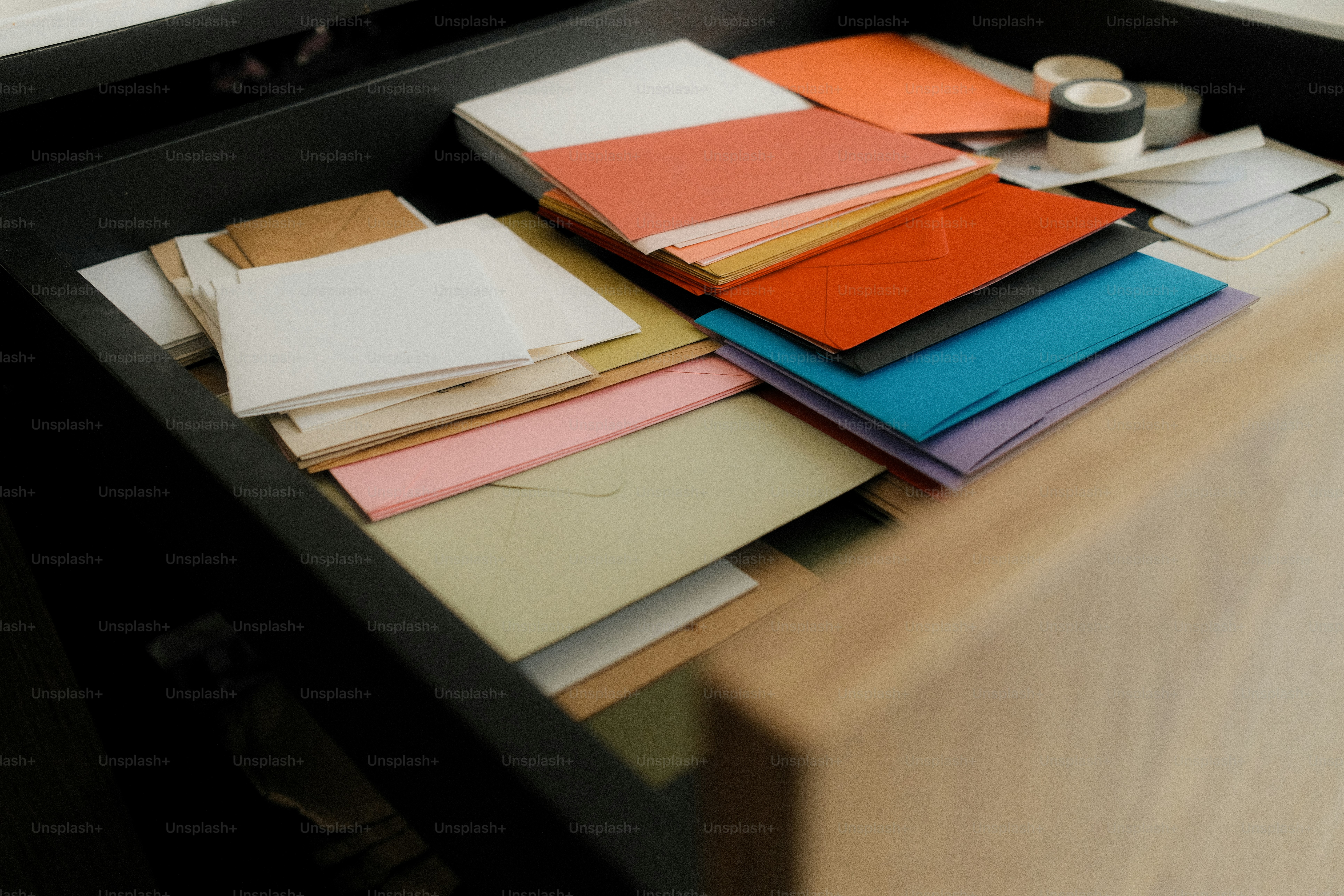 Drawer filled with colorful envelopes and paper. photo – Stationery ...