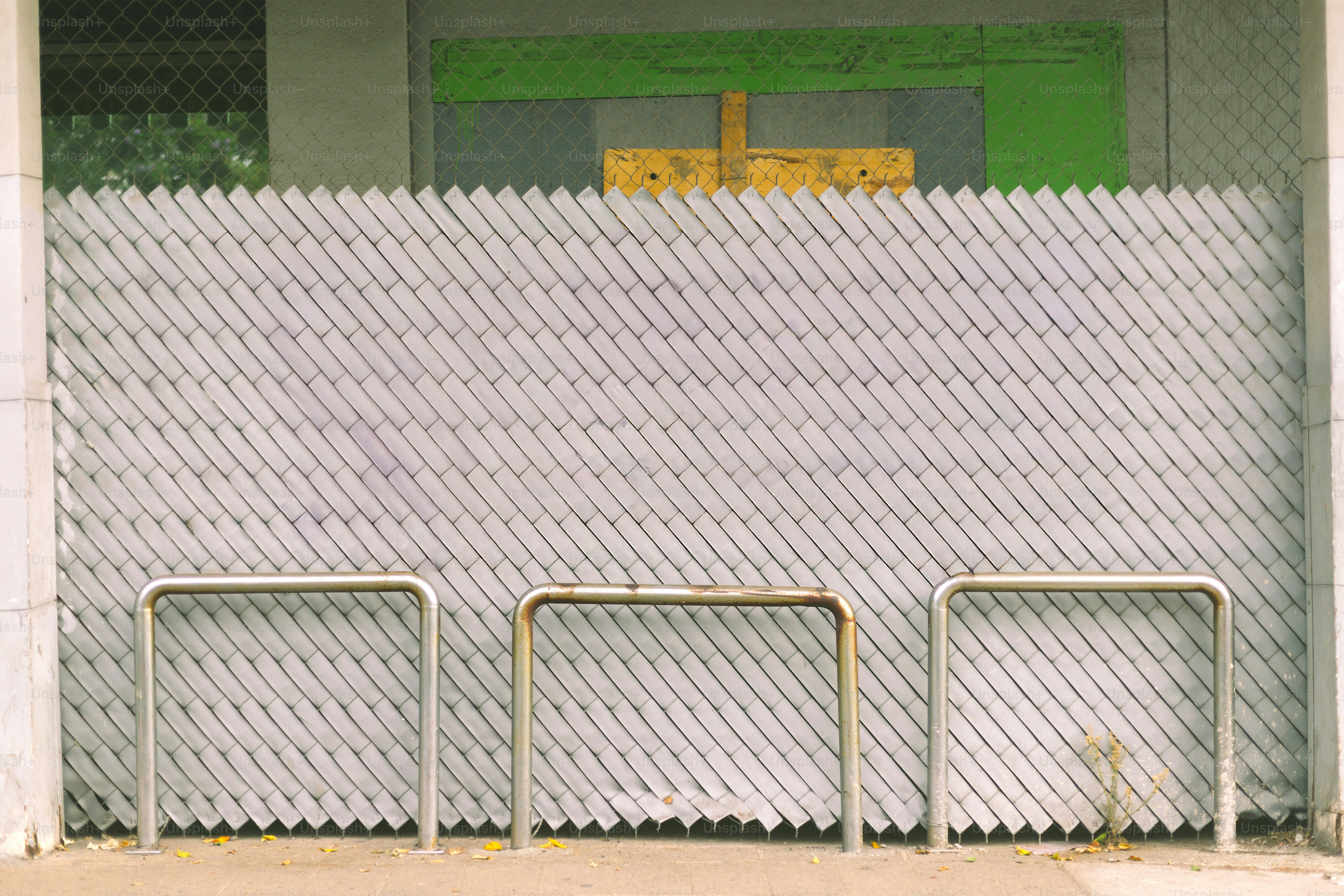 A fence stands in front of bicycle racks. photo – City Image on Unsplash