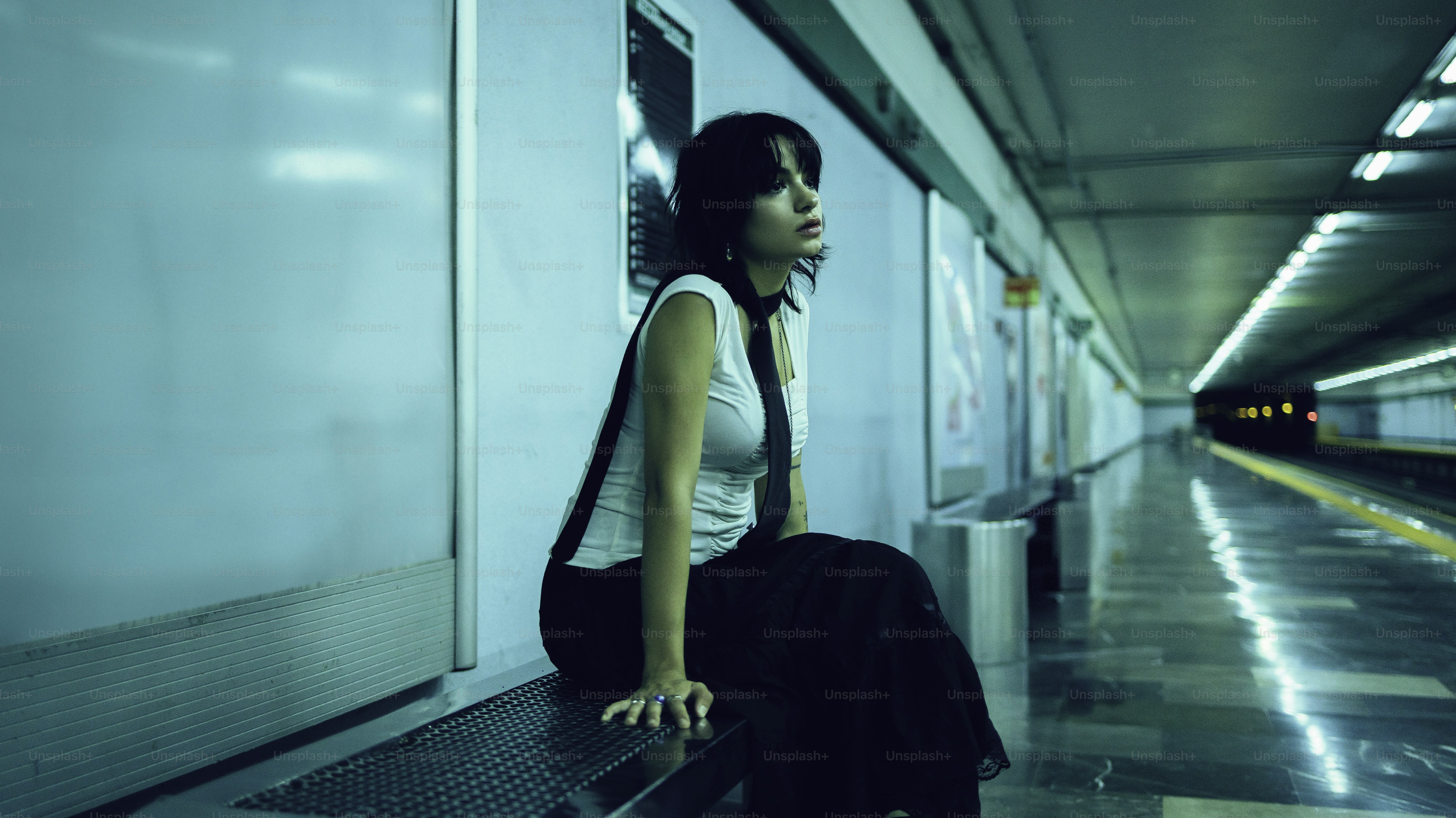 Woman sits alone and waits in a subway station. photo – Alone Image on ...
