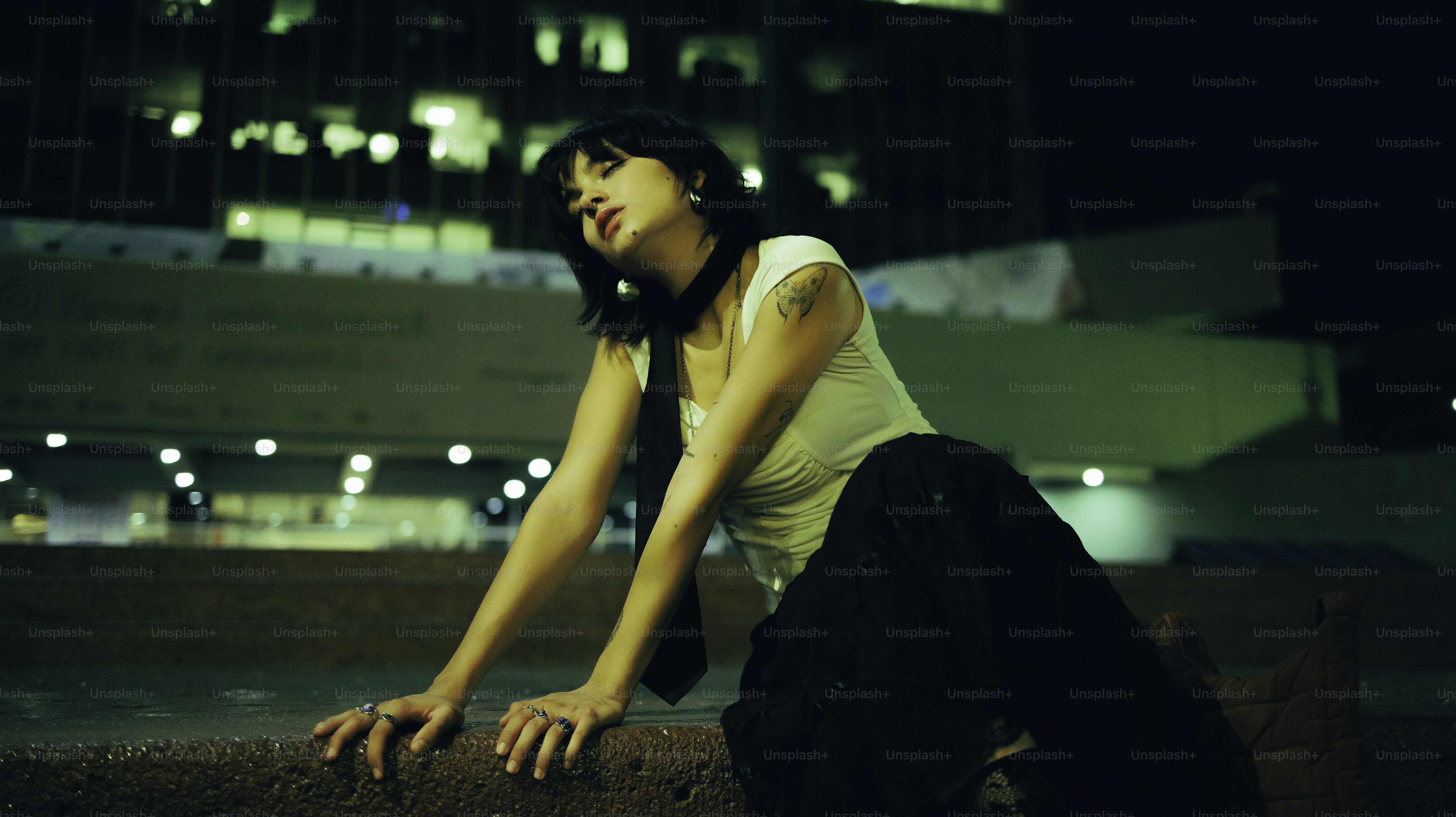 Woman poses on a ledge at night. photo – Night city Image on Unsplash