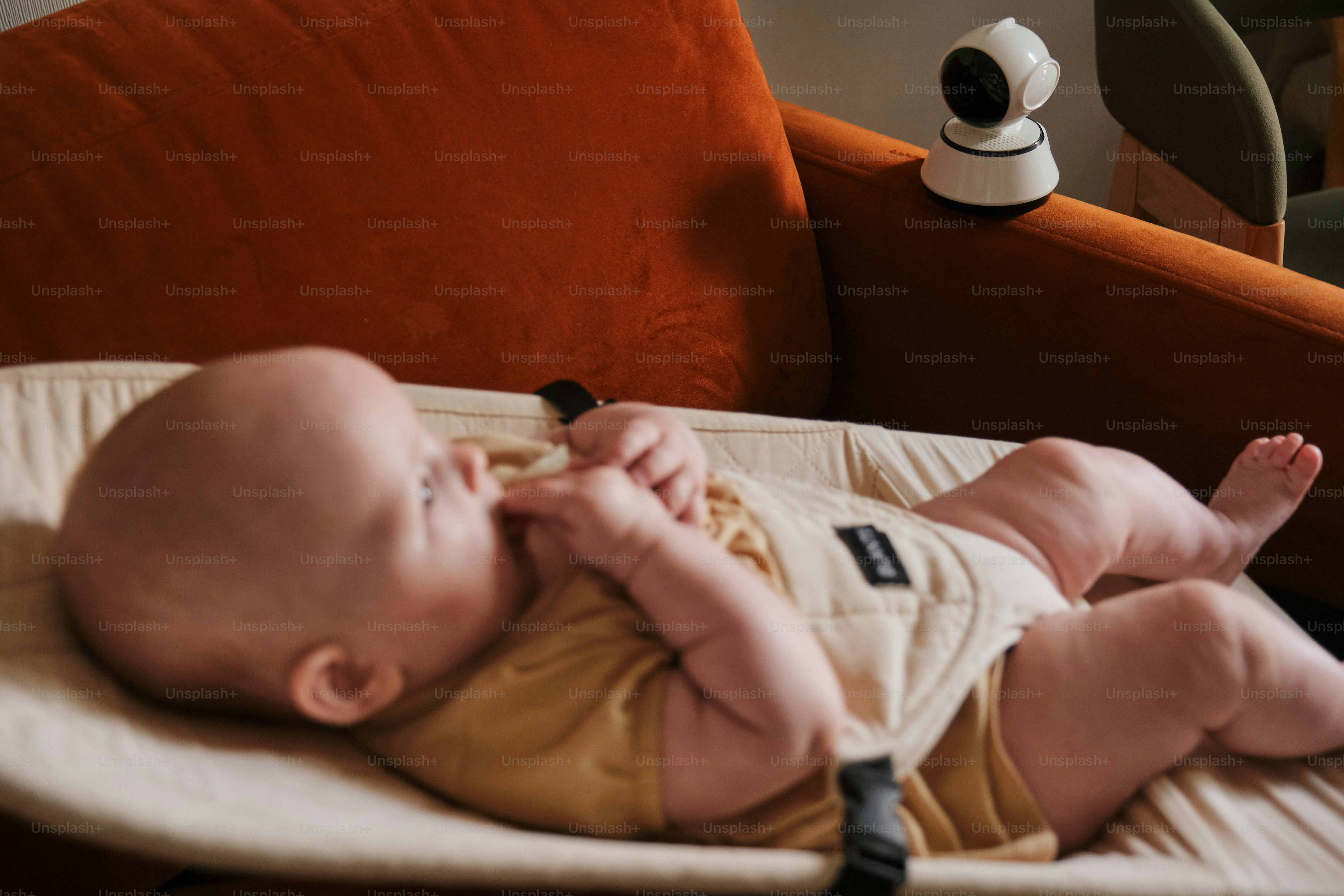 A baby watches a camera from a comfy chair. photo – Technology Image on ...