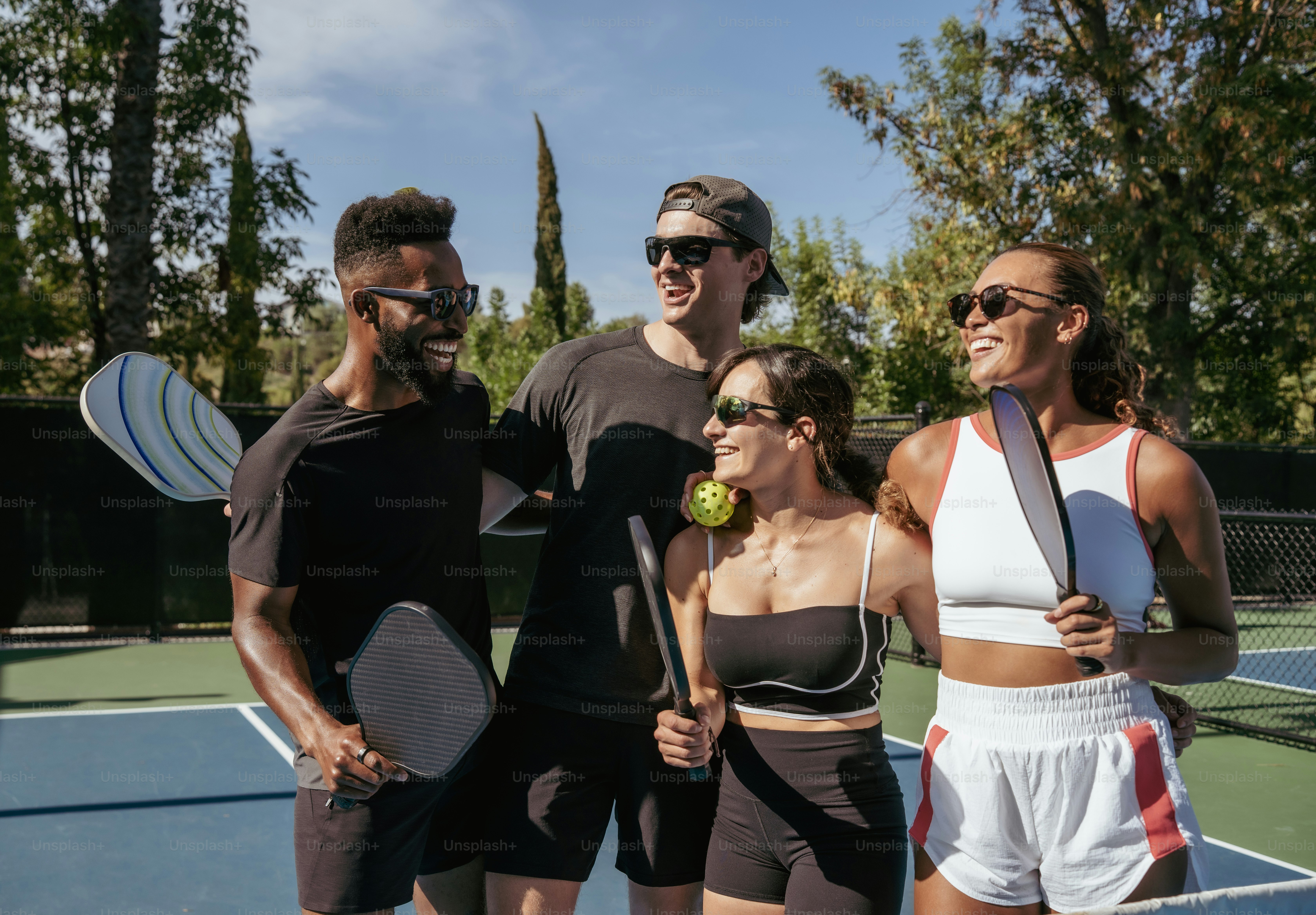 Four friends are smiling with pickleball paddles. photo – Sports Image ...