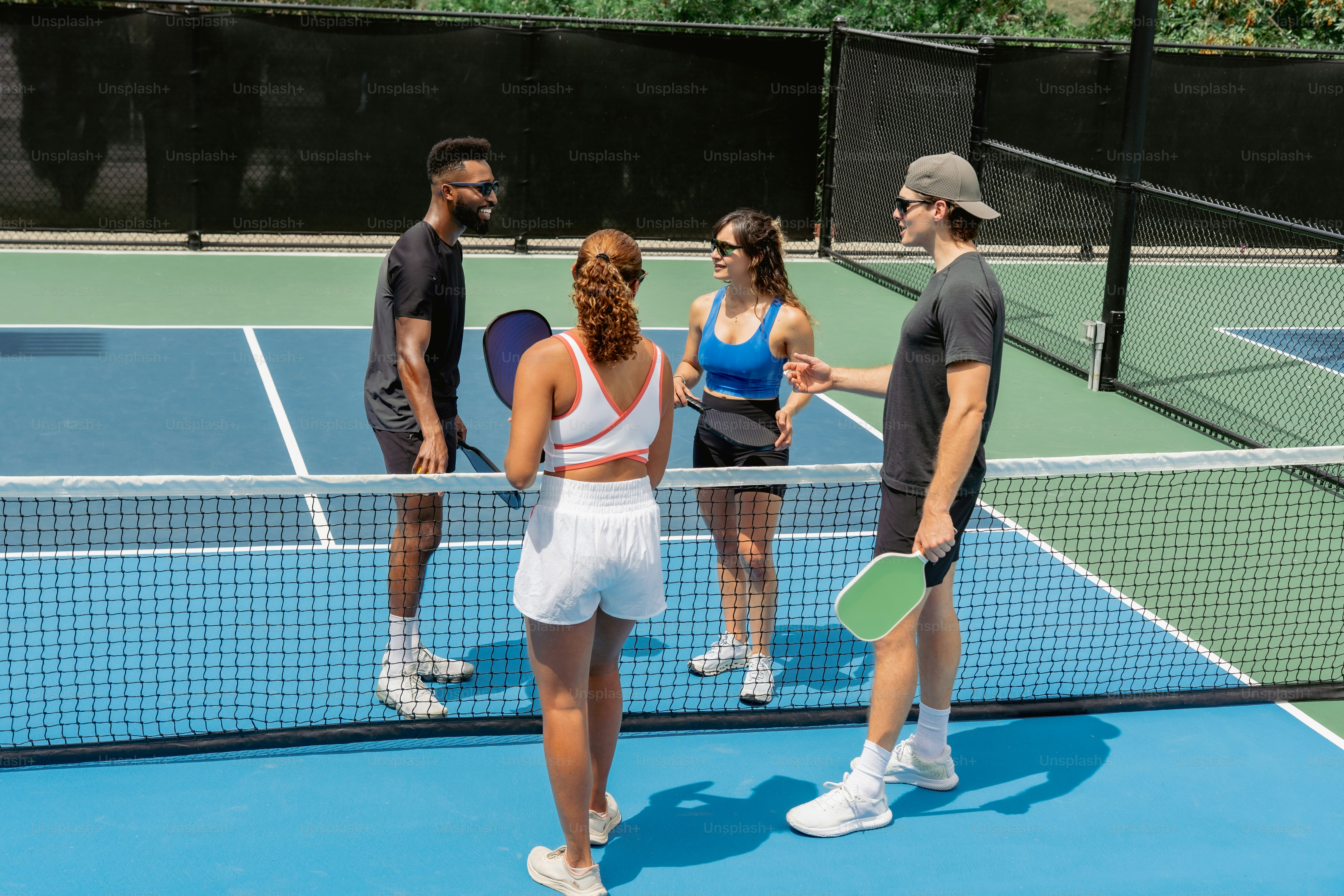 Four friends play pickleball on the court together. photo – Sports ...