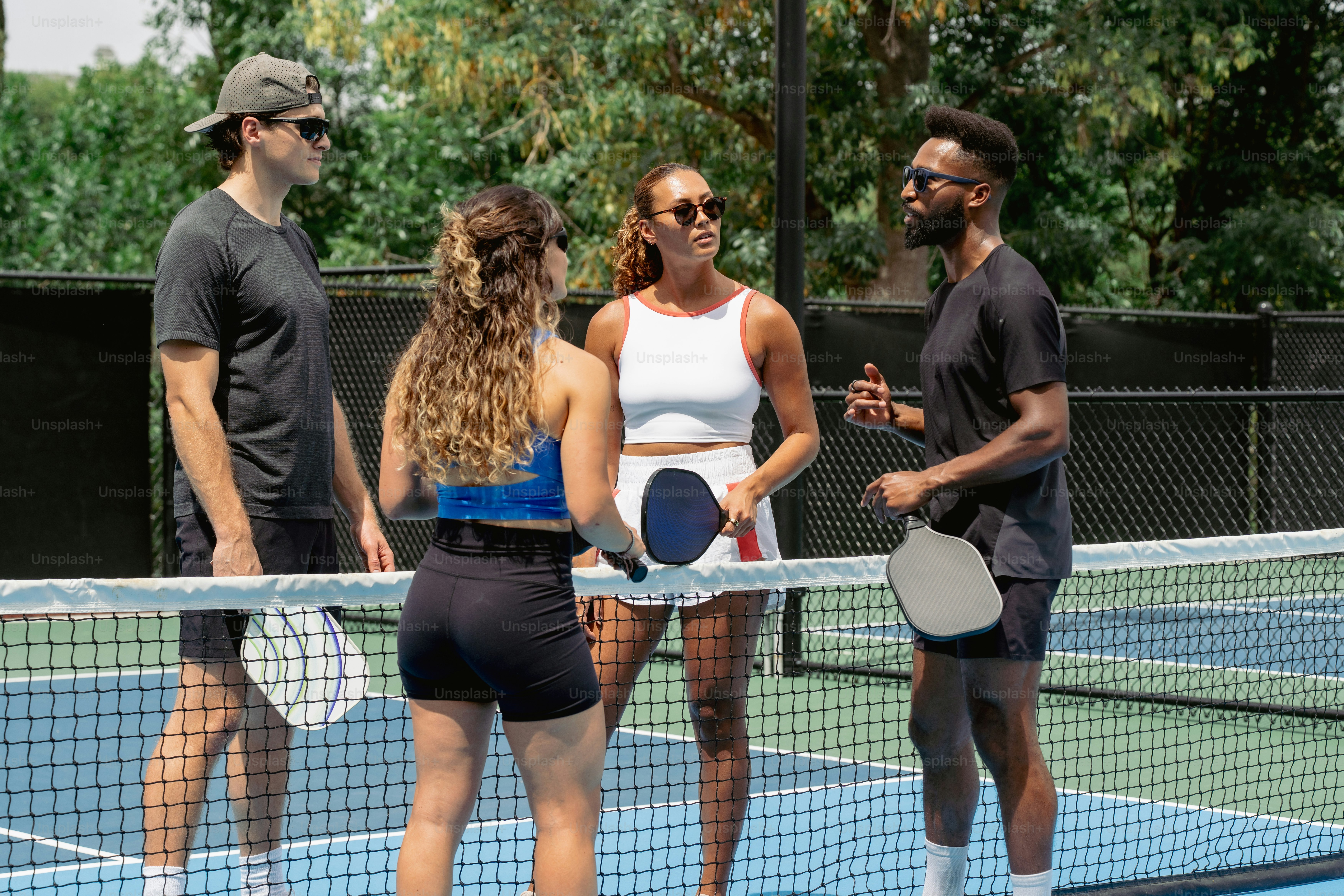 Four friends are playing pickleball outdoors. photo – Sports Image on ...