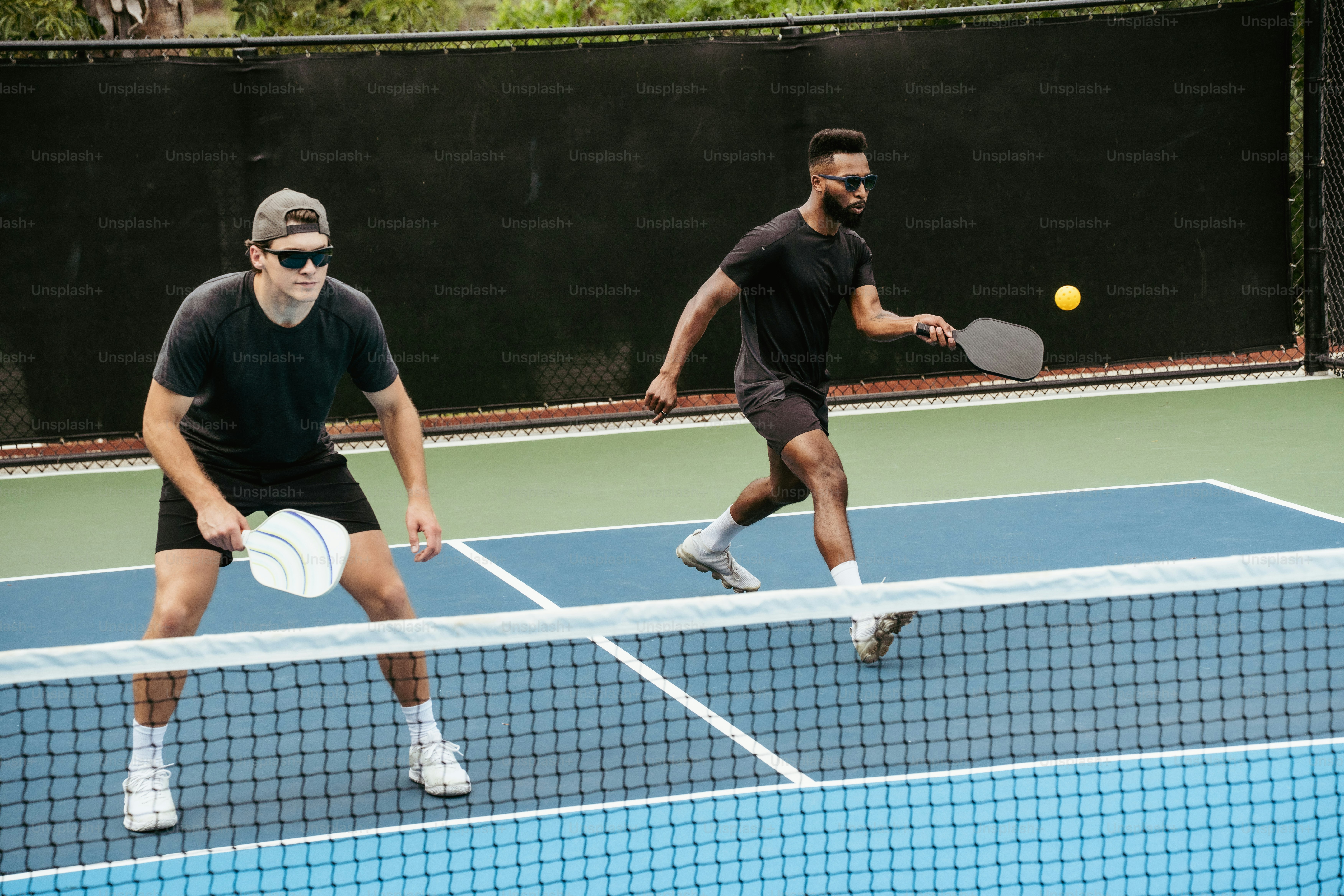 Two men play pickleball on a court. photo – Sports Image on Unsplash